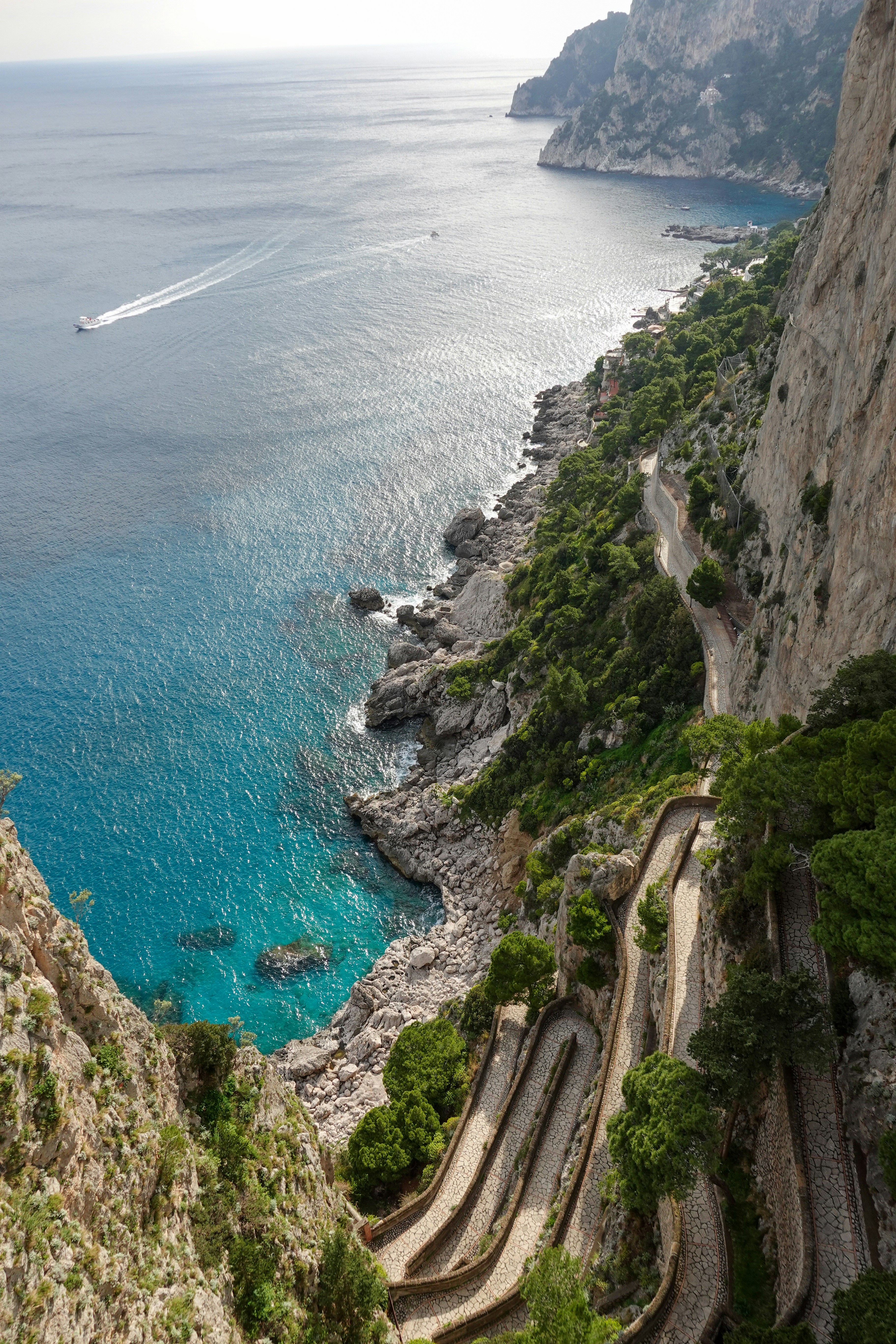 Terraced coastal steps tracing a village’s edge down to turquoise sea