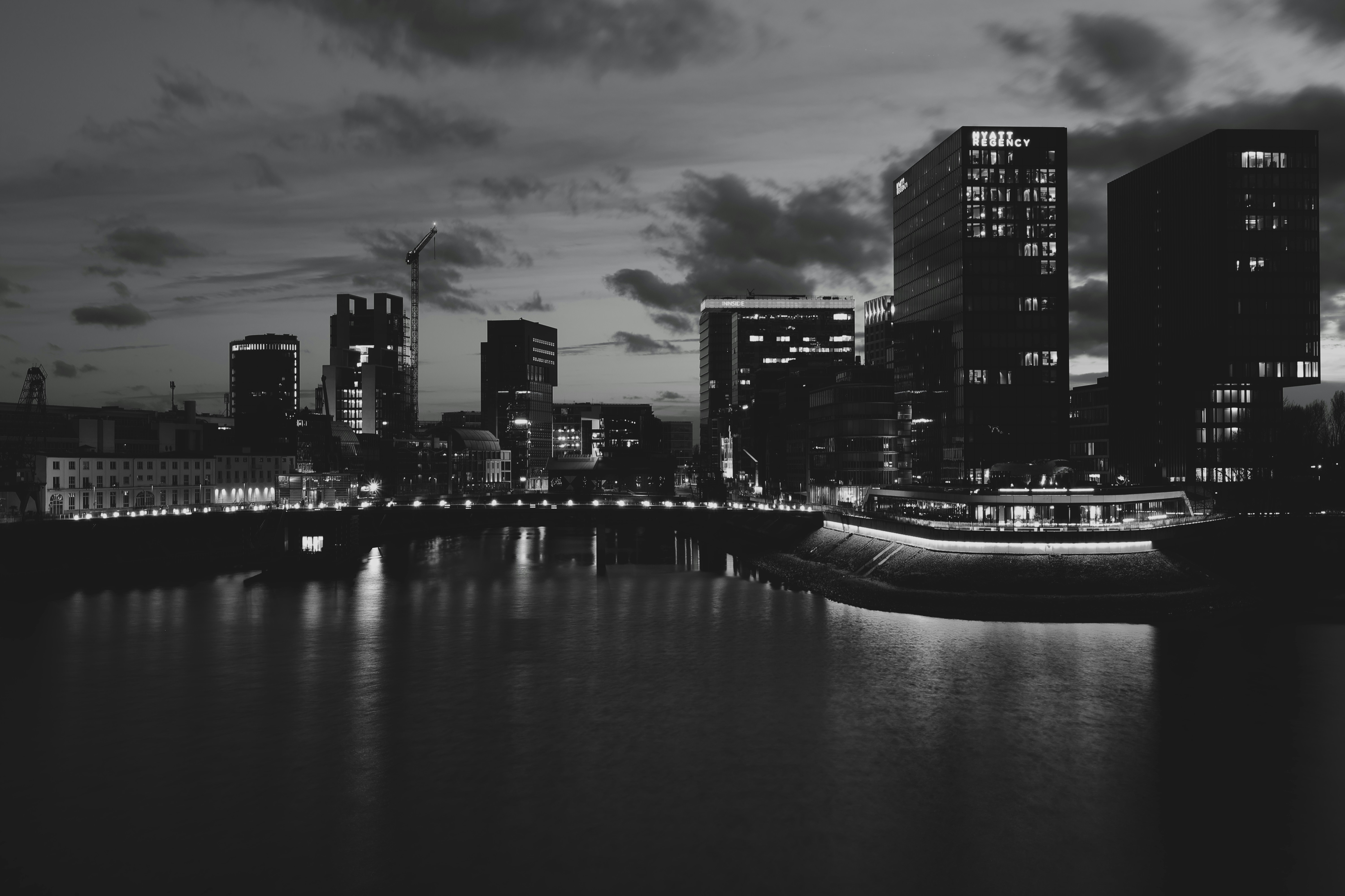 Midnight Waterfront Silhouette: City Lights Over Calm Water