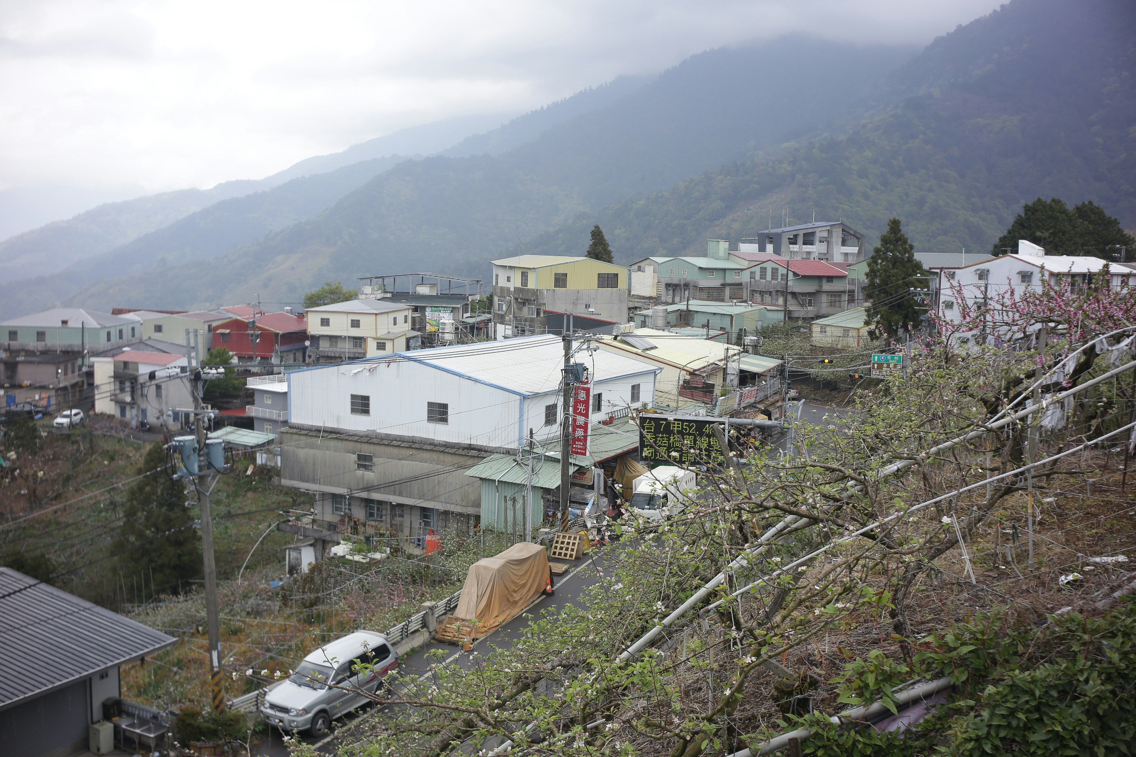 Colorful hillside town under mist with tangled utility poles
