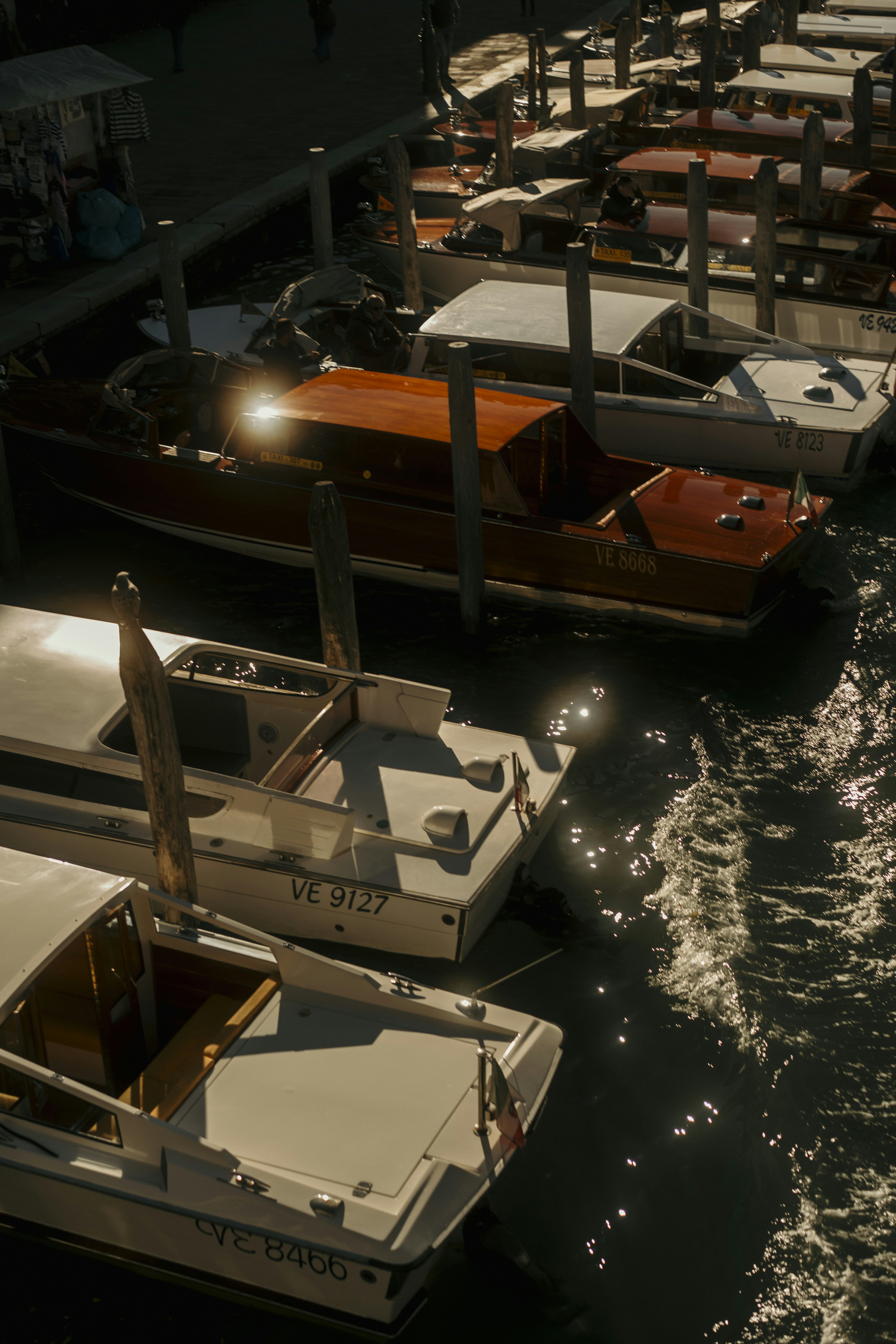 Sunlit Hulls: A Row of Boats Whispering Along the Docks