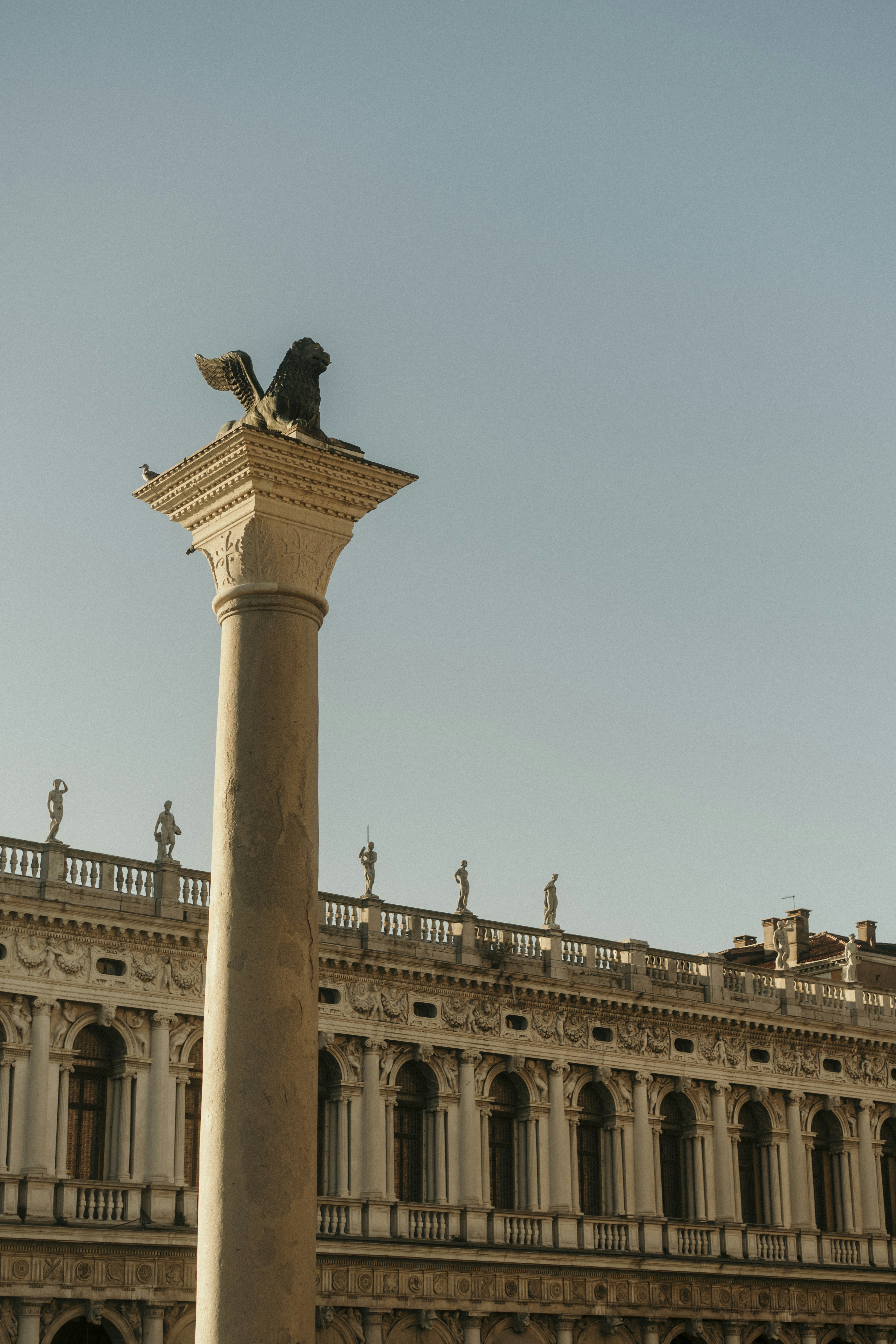 Stone Column Crowned by a Griffon Watching Over a Classical Arcade