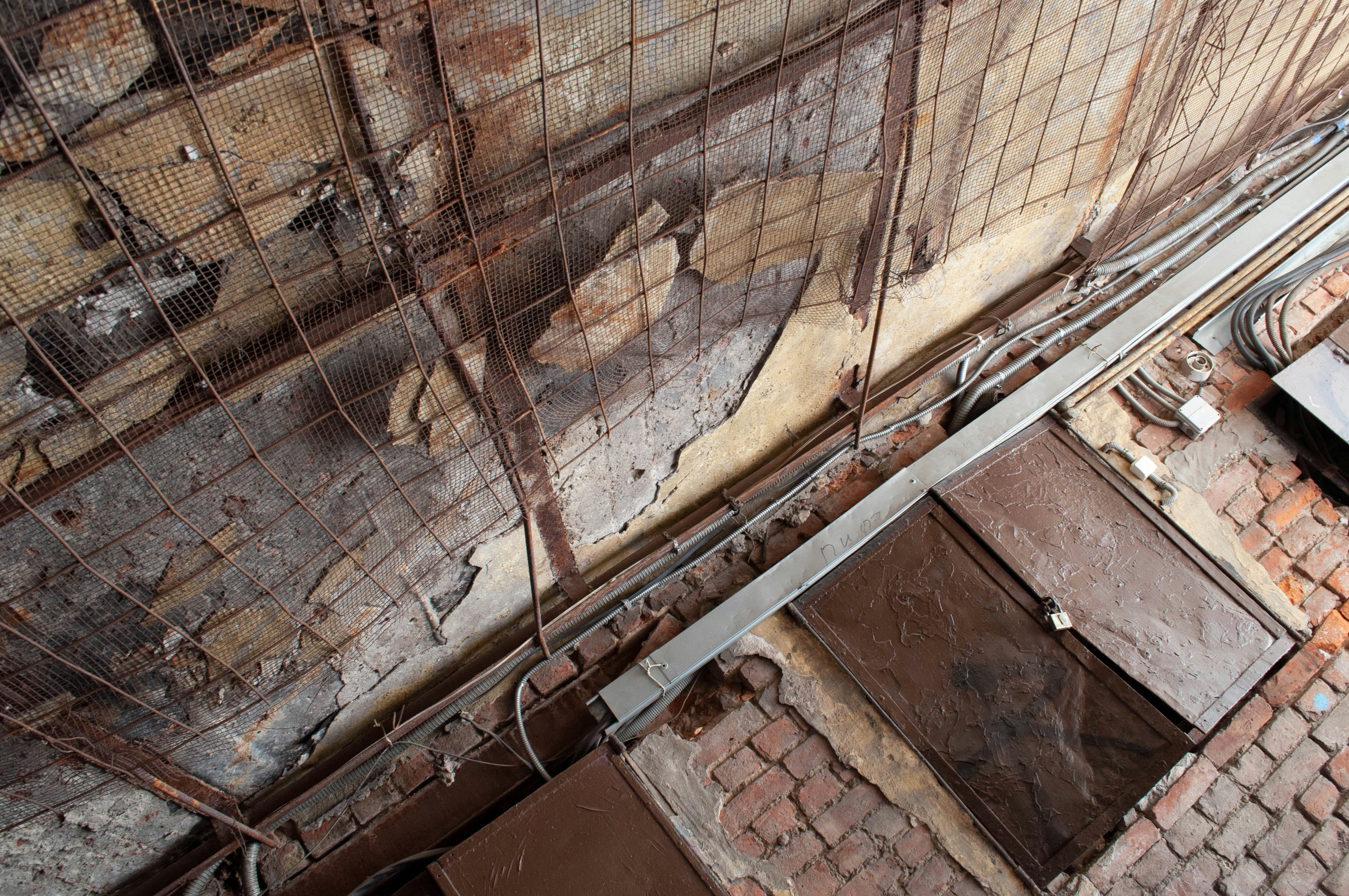 Rusted Ventures: A Decaying Industrial Interior with Exposed Bricks and Wire Mesh
