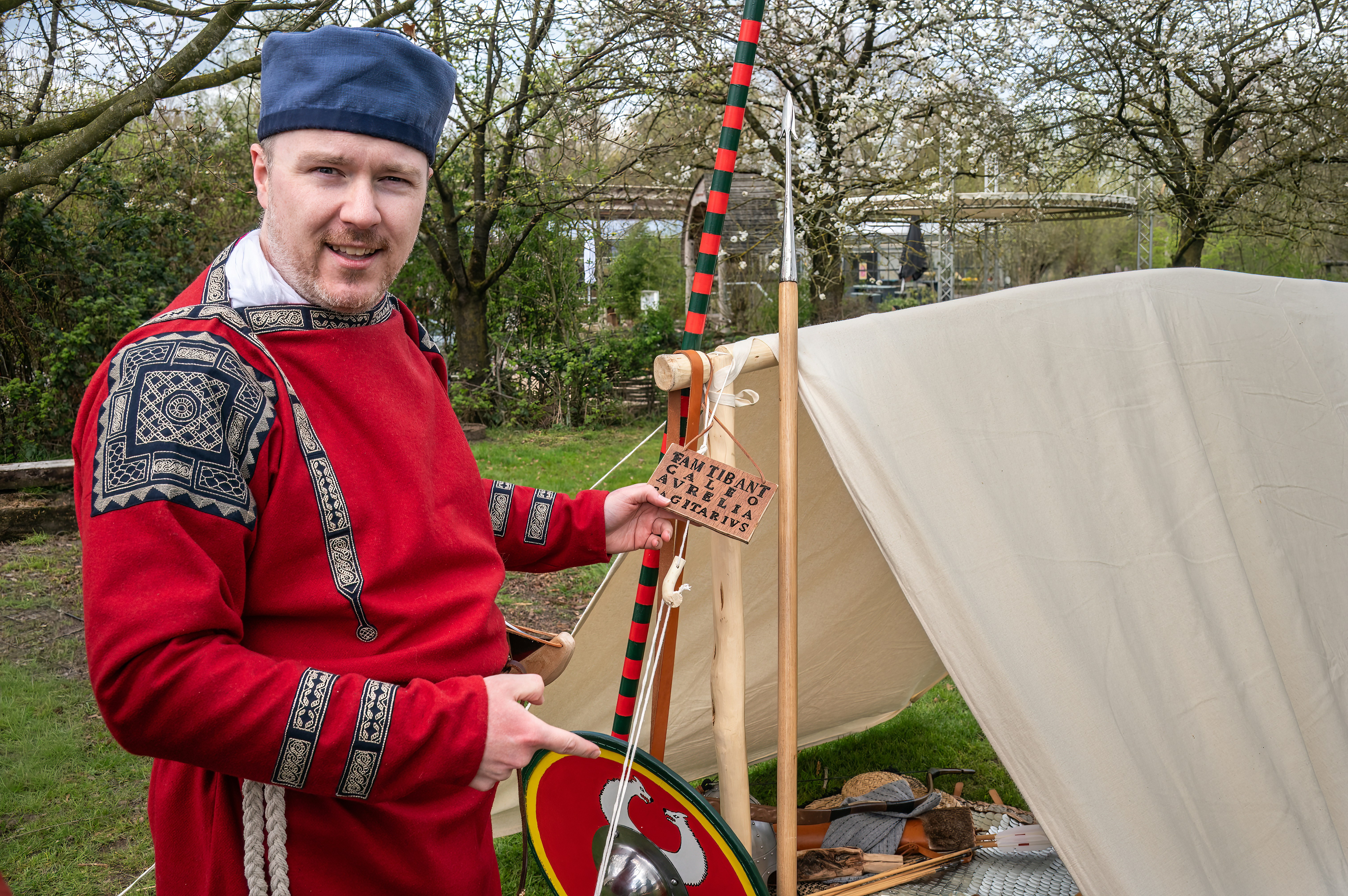 Herald of the Field: A reenactor in red tunic beside a canvas pavilion