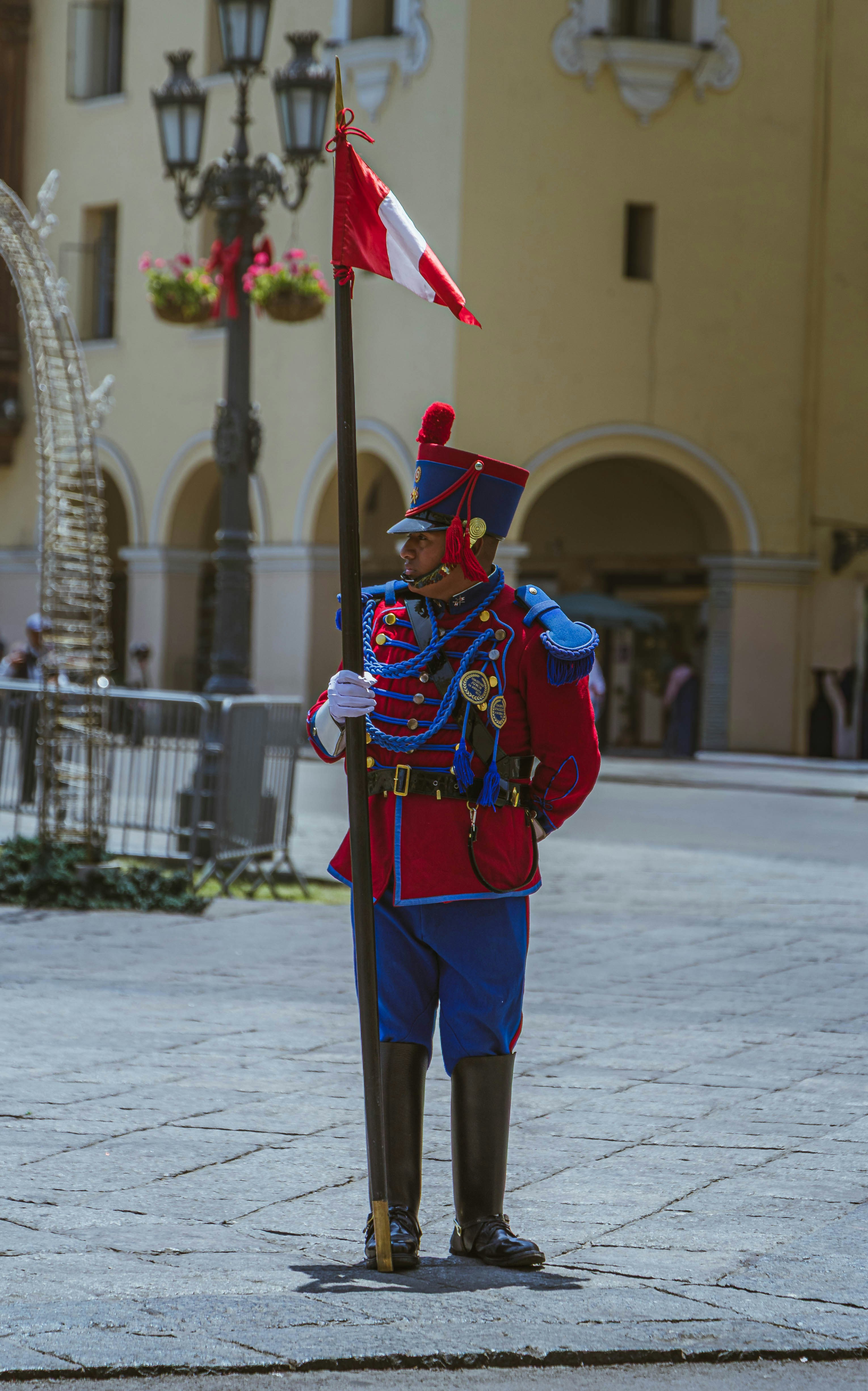 Guard in ceremonial uniform holding a flag