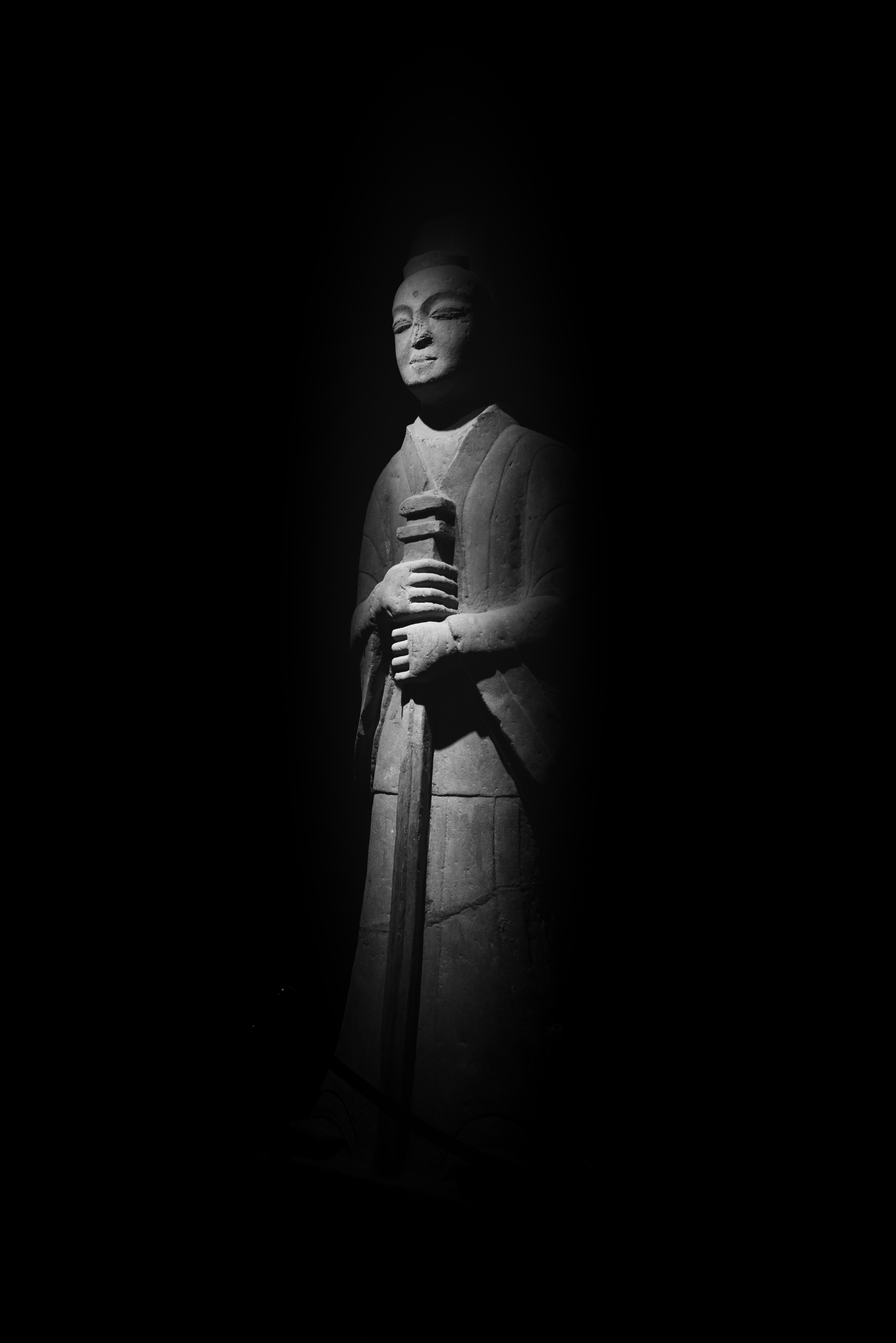 Spotlit Sentinel: A Silent Statue Emerges from Darkness