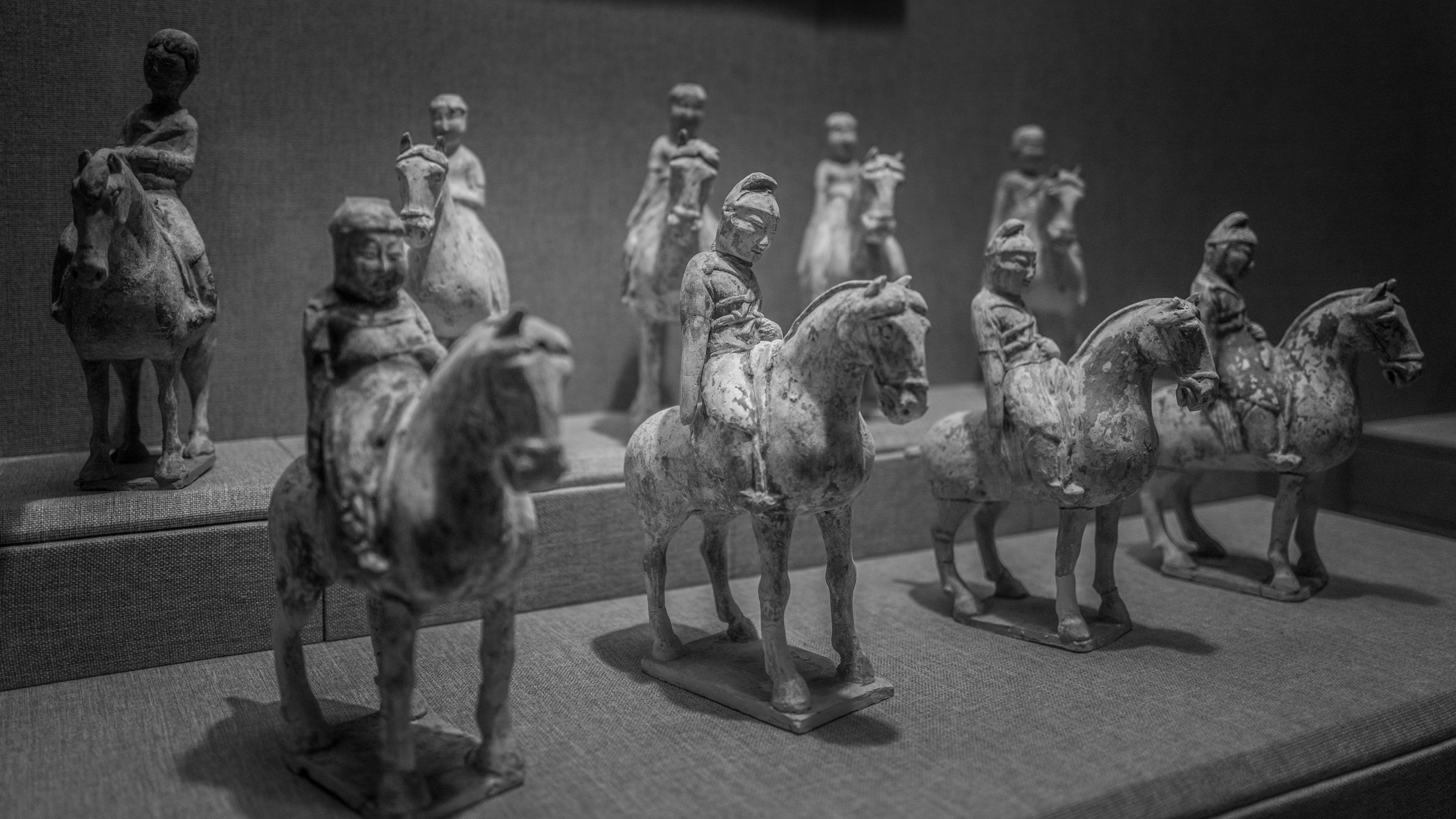 Staged Caravan: Tiny Horsemen in a Quiet Gallery