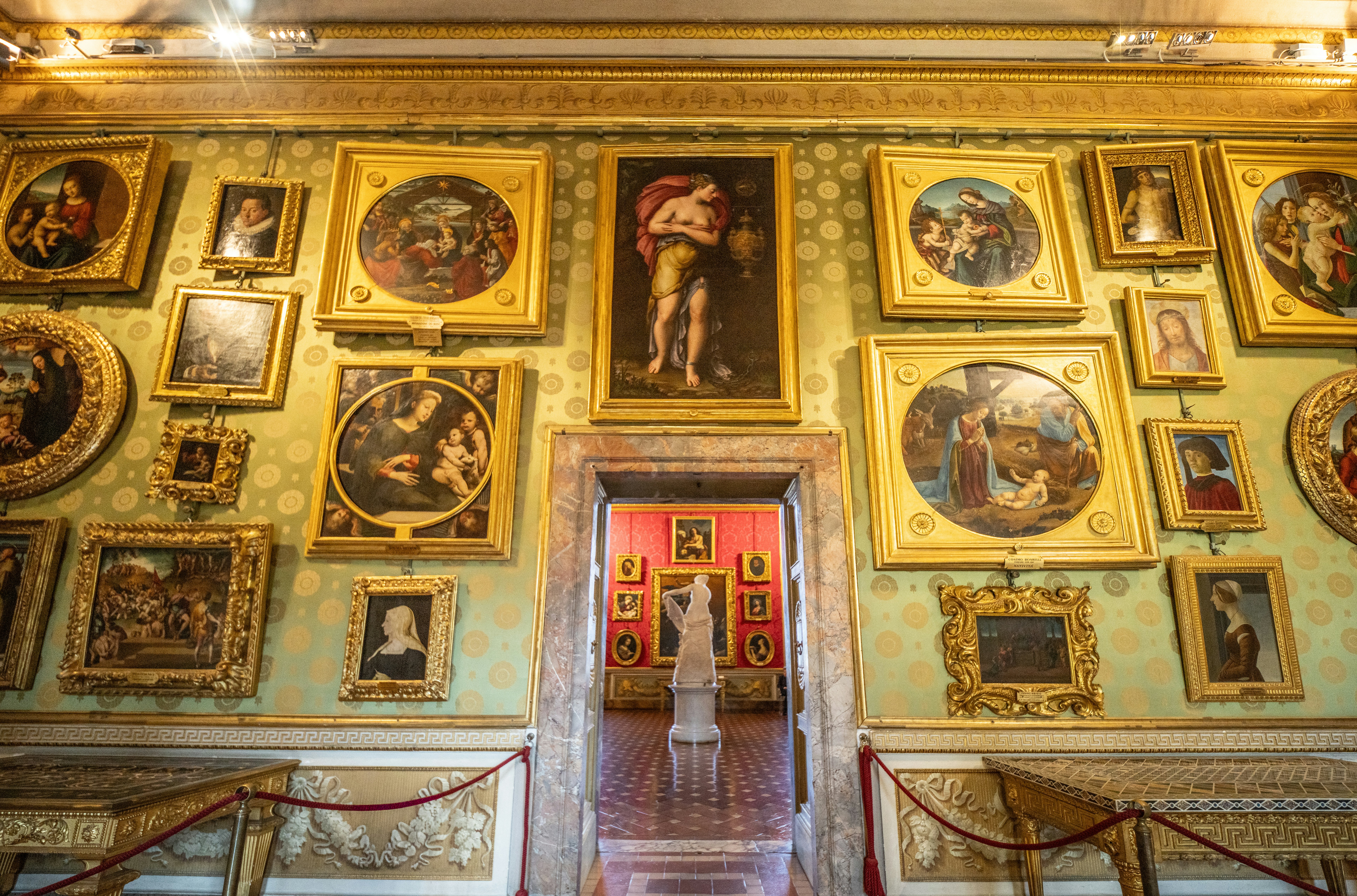 Gilded Gallery Corridor: Portraits Framing a Red-Walled Niche