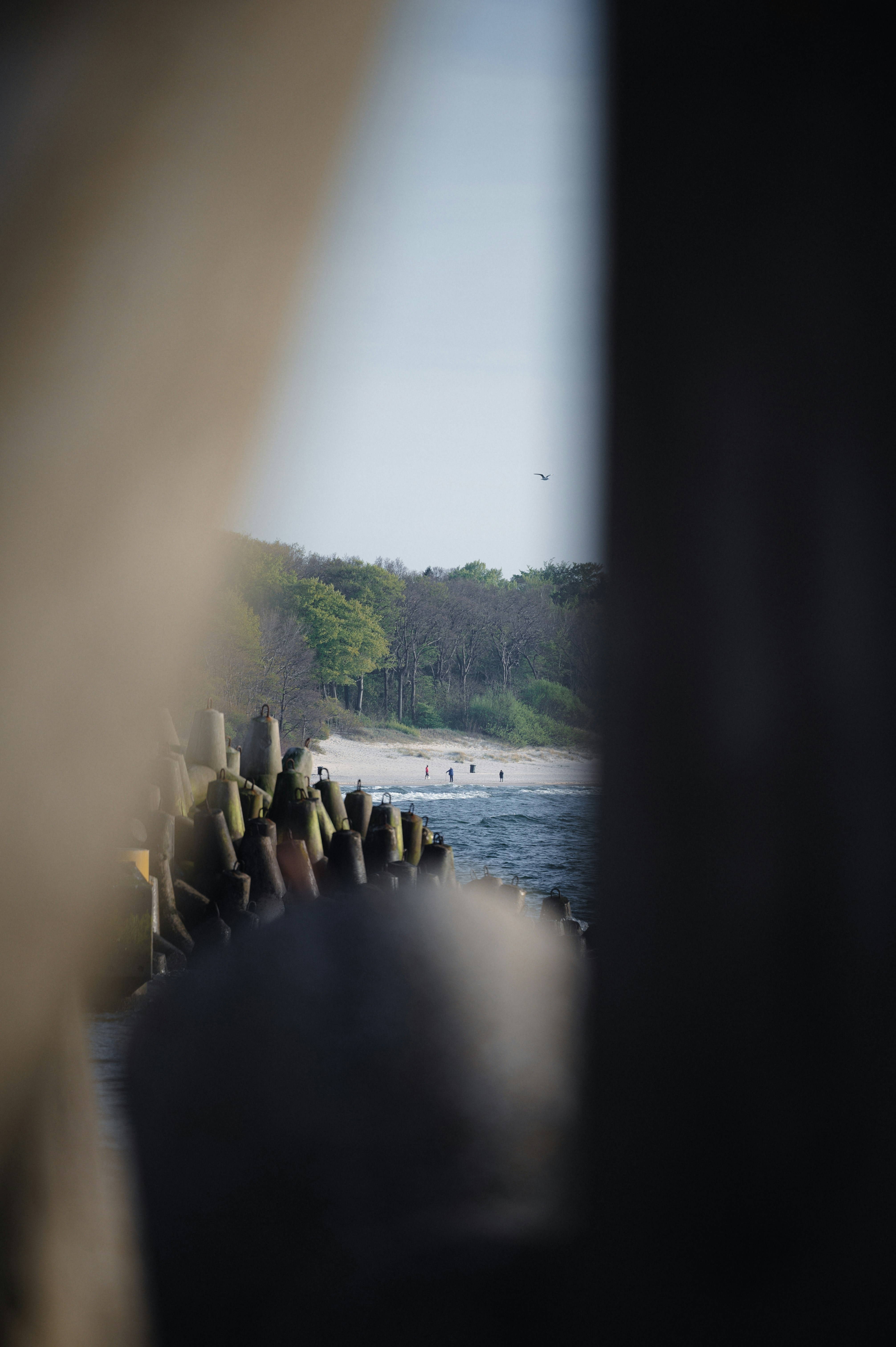 Hidden Shoreline: Boats, Breakwaters, and a Distant Sea