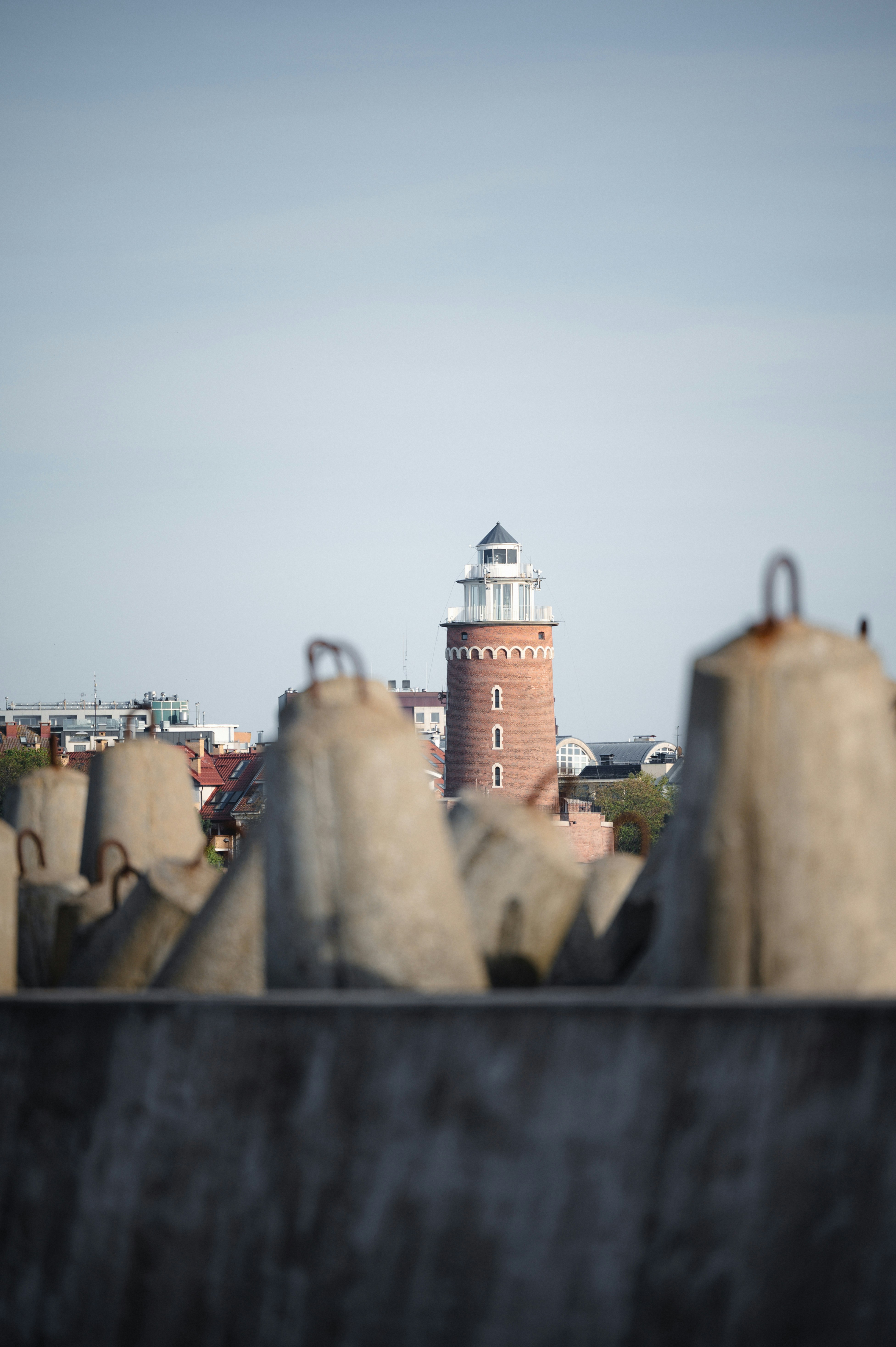 Lighthouse Rising Beyond the Concrete Breakwaters