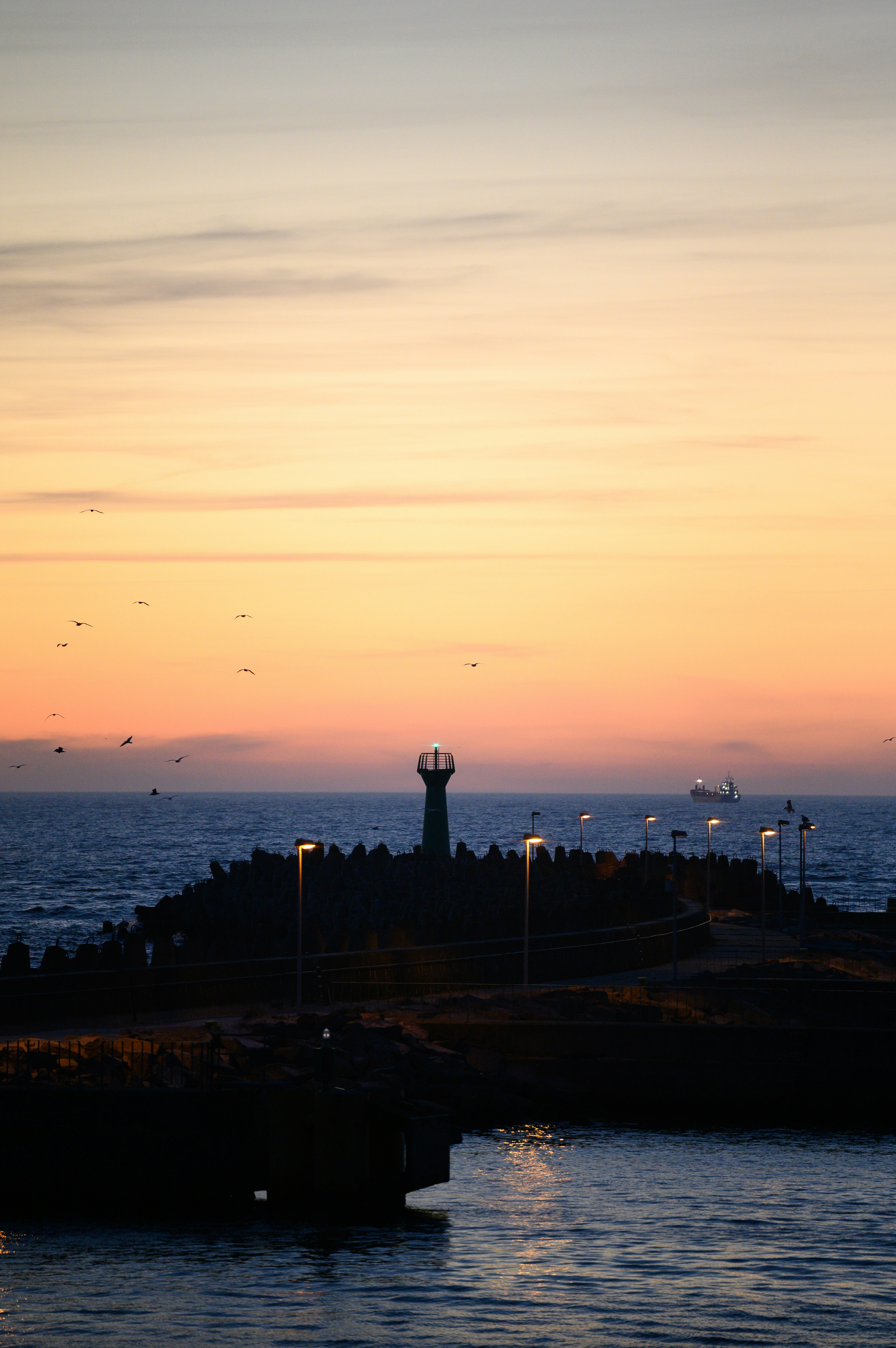 Lighthouse Sentinel at Dusk Over a Tranquil Pier
