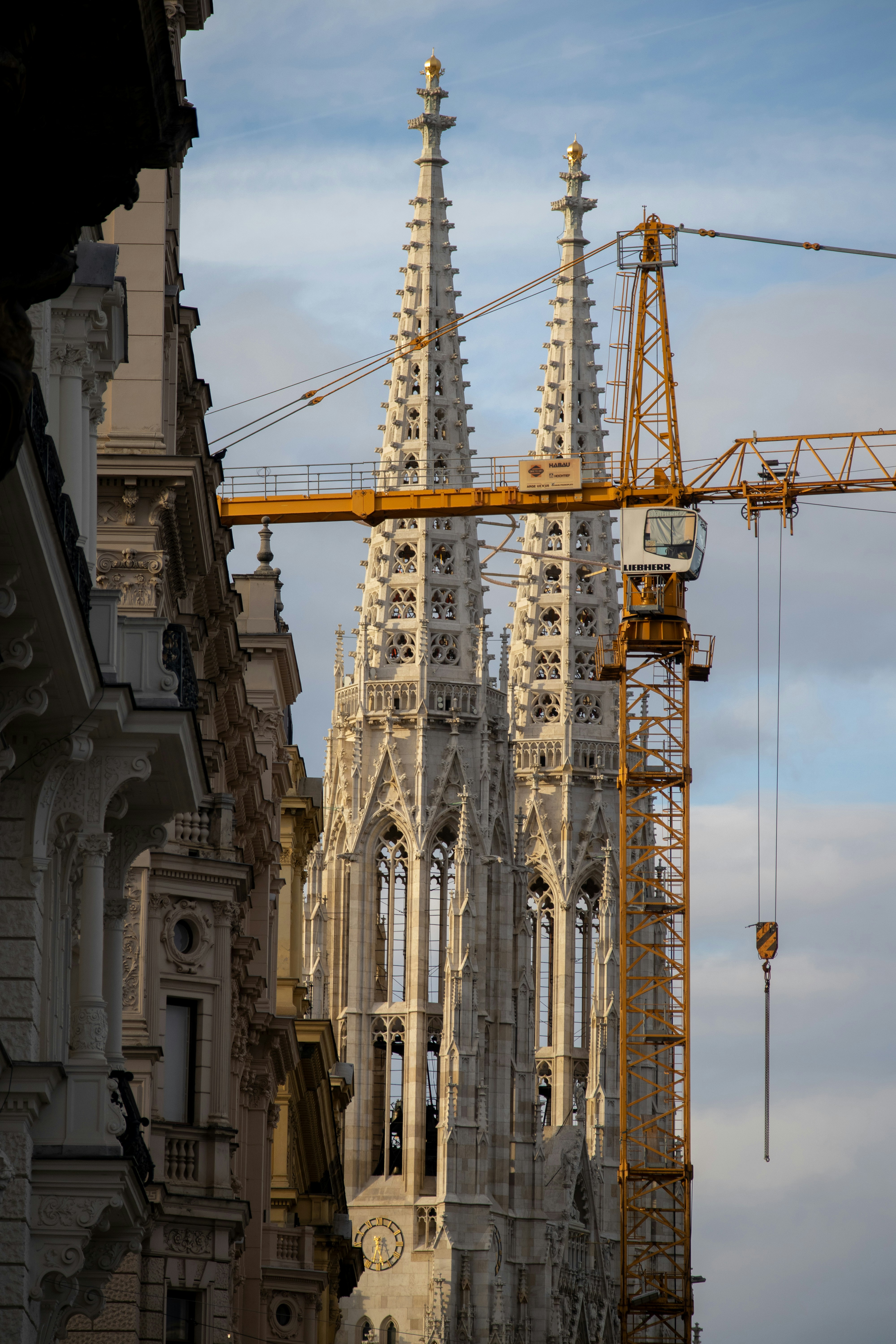 Crane Meets Cathedral Spires: Urban Construction Framing a Historic Façade