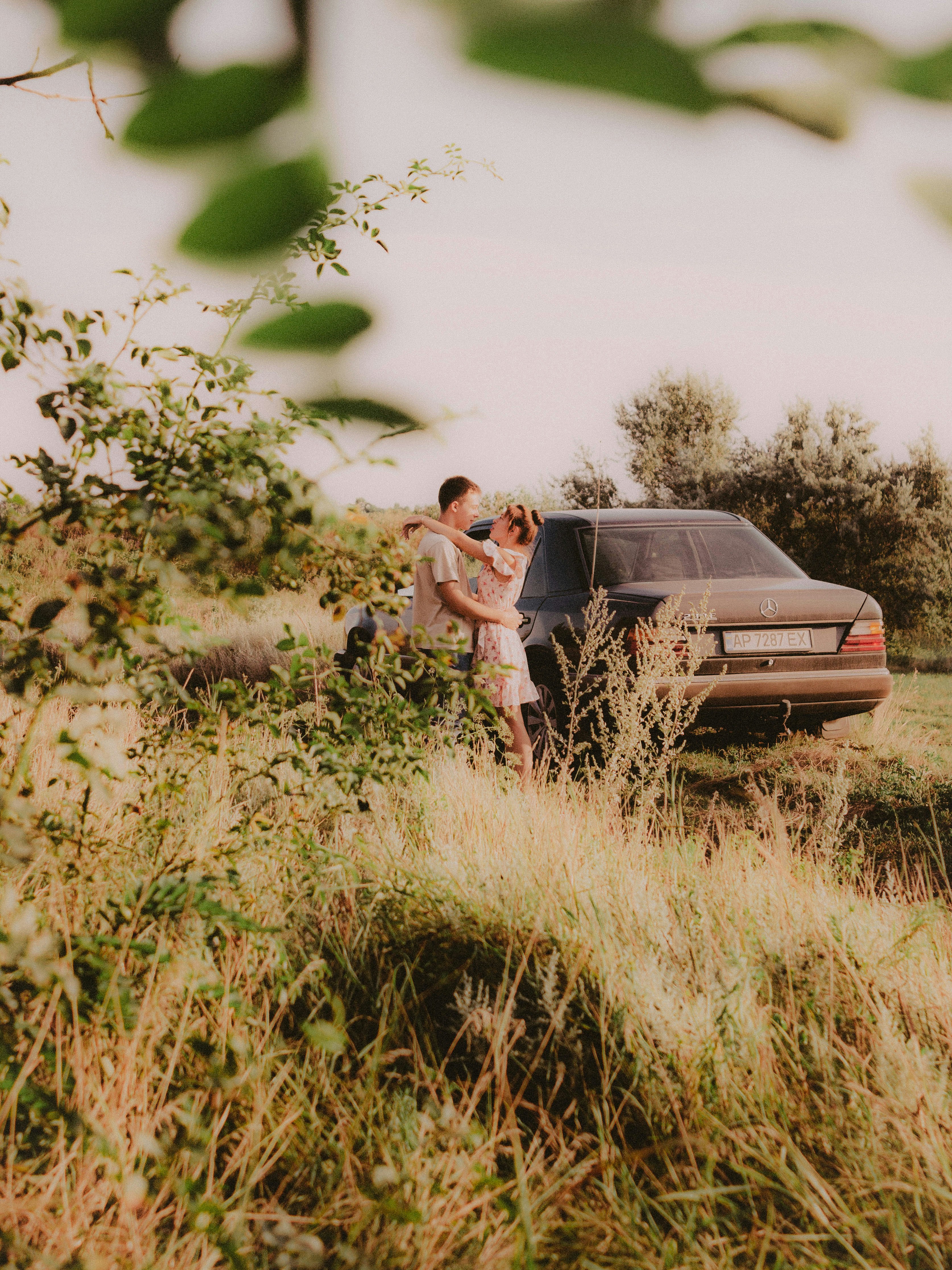 A Quiet Embrace by the Car in Golden Field