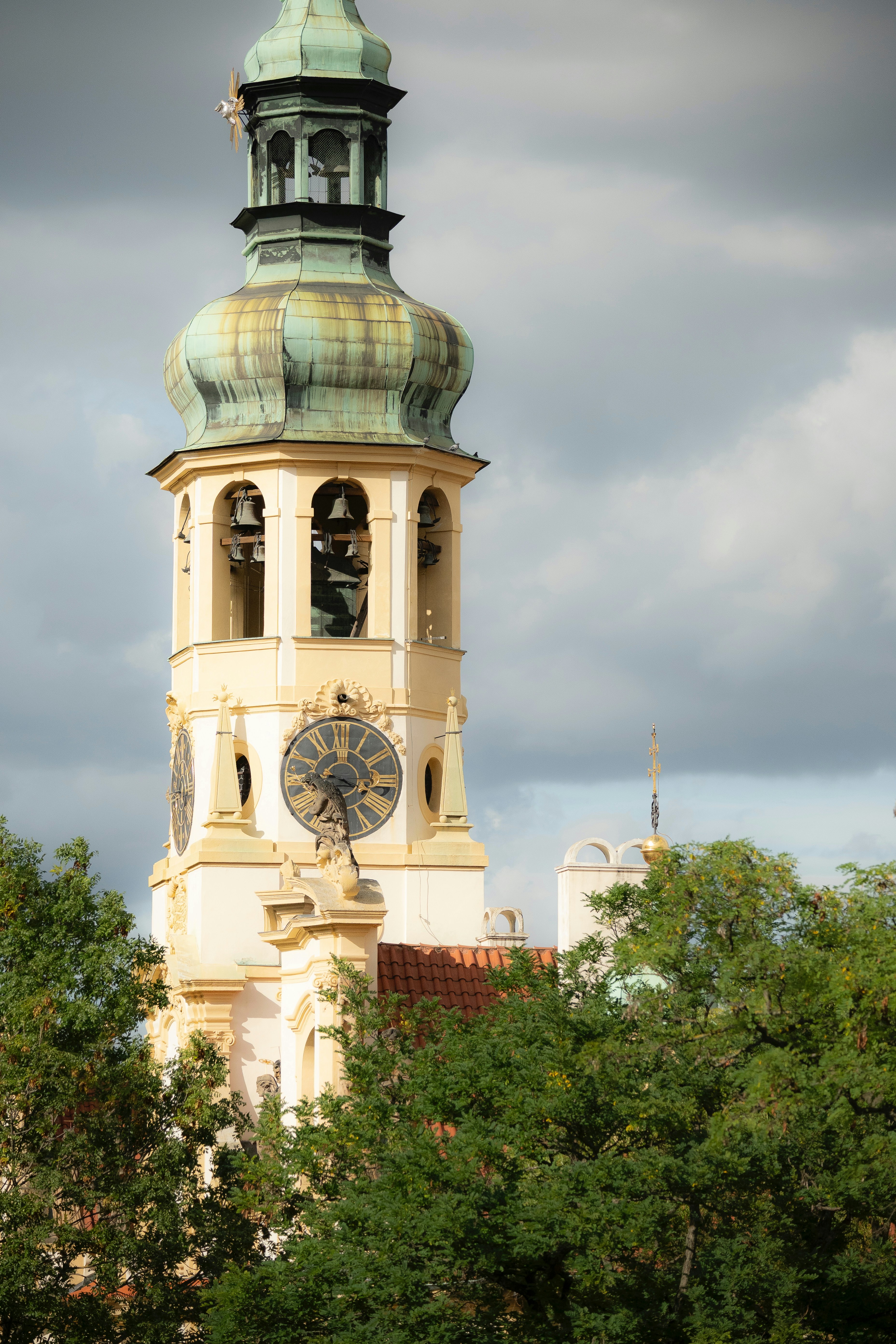 Heritage Clock Tower Reaches Skyward Amid Green Canopy