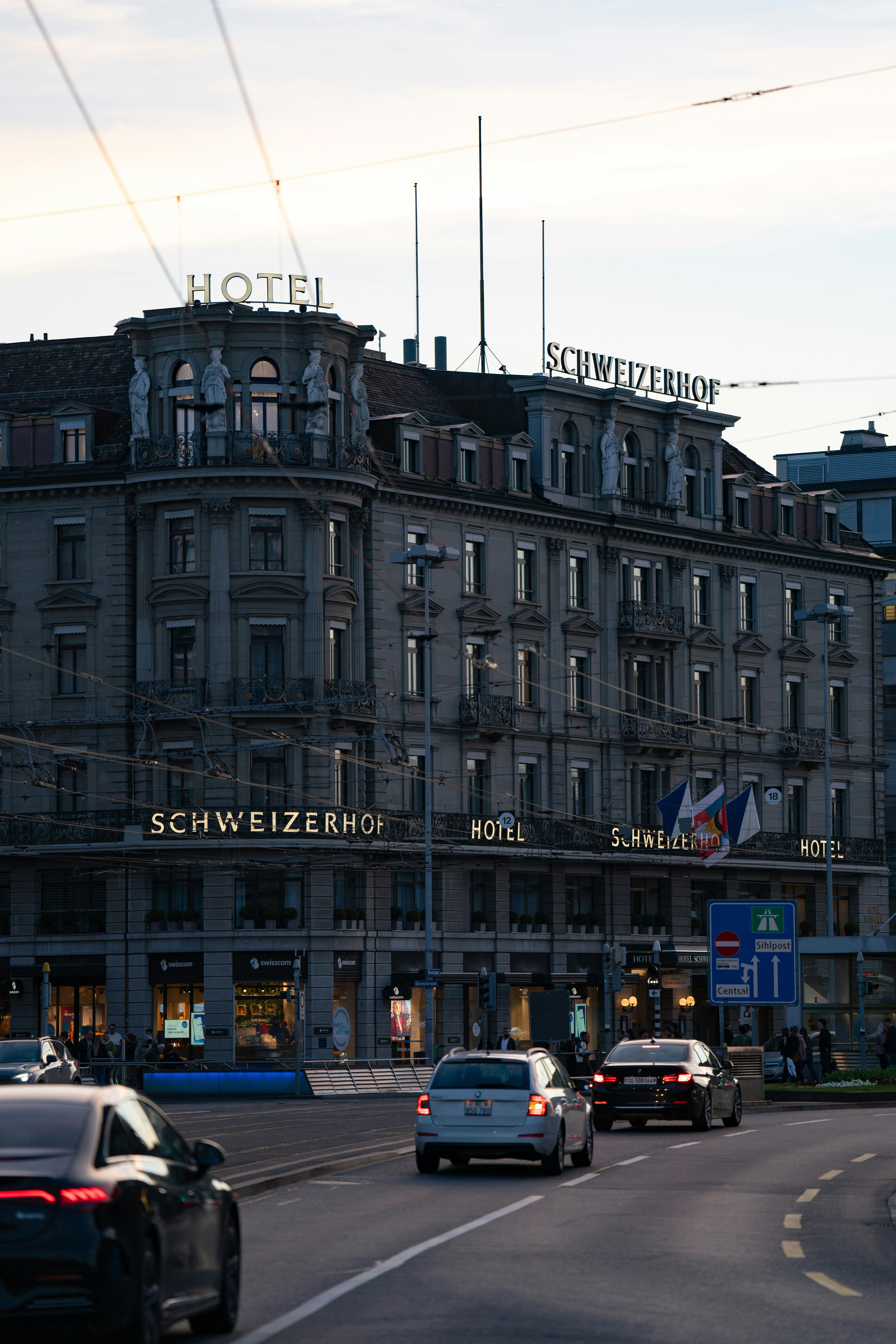 Hotel Schweitzerhof: Facades, Neon Lights, and City Traffic at Dusk