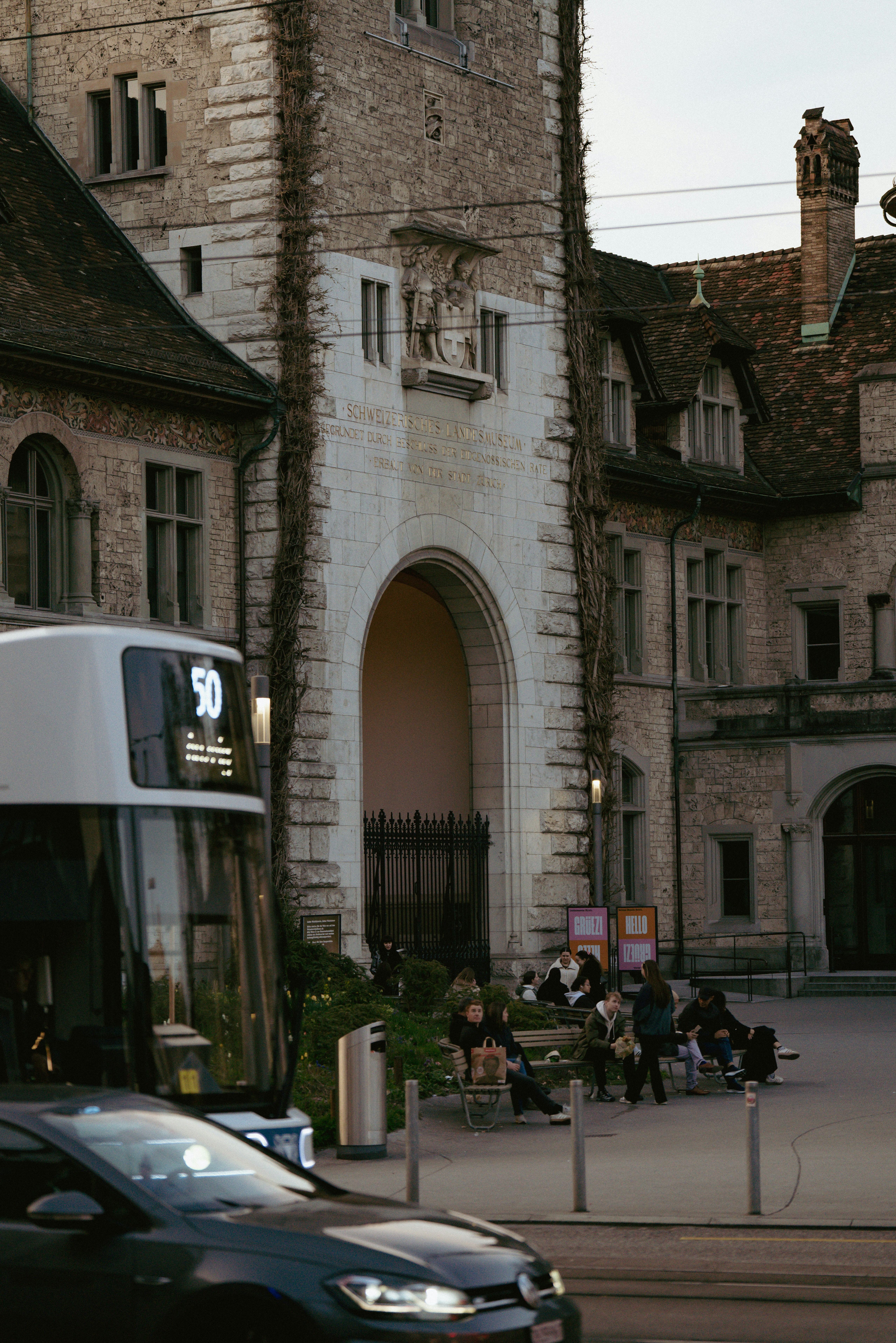Urban Portrait at the Archway: People, Bus, and Historic Facade