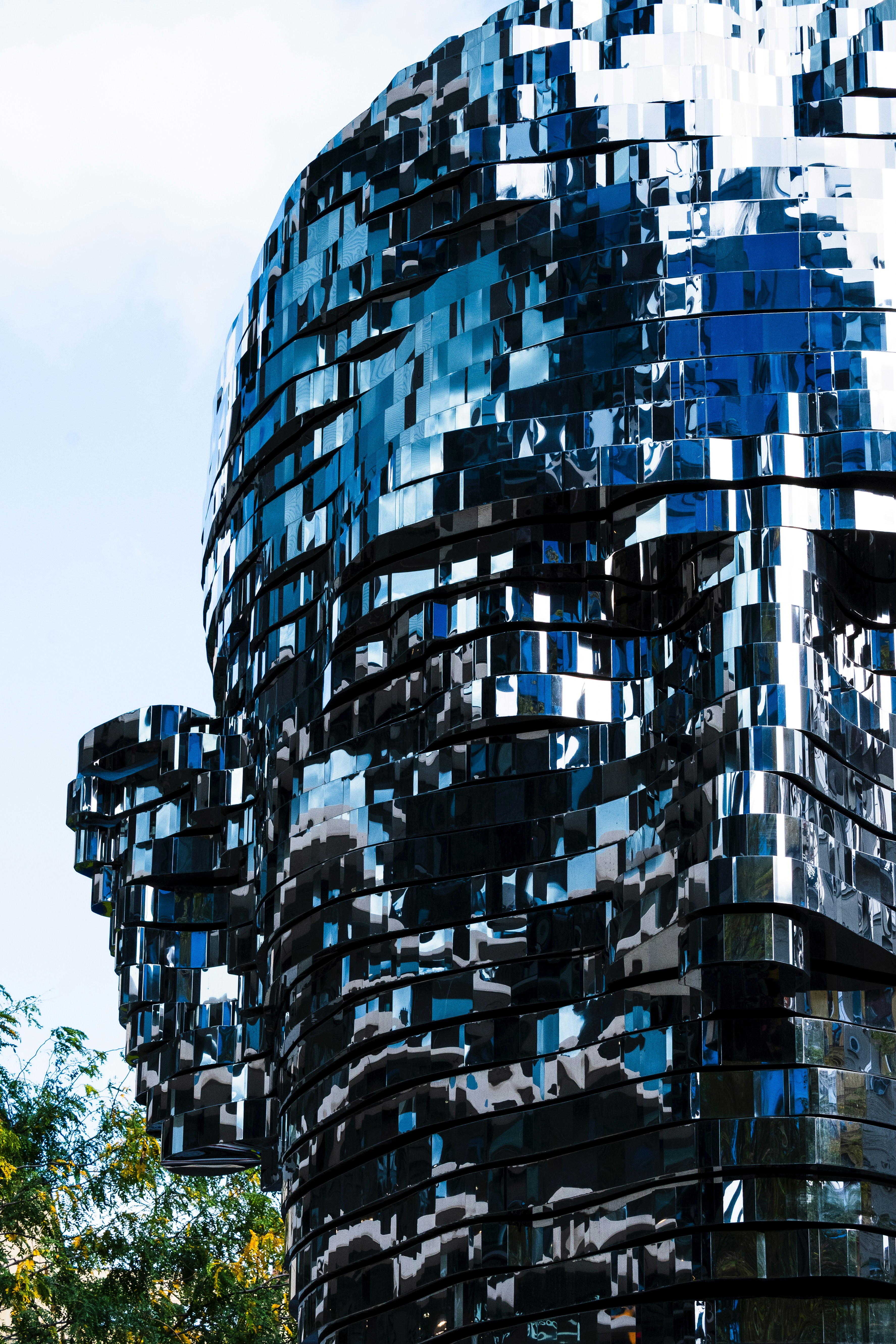 Large metallic head sculpture made of reflective panels.