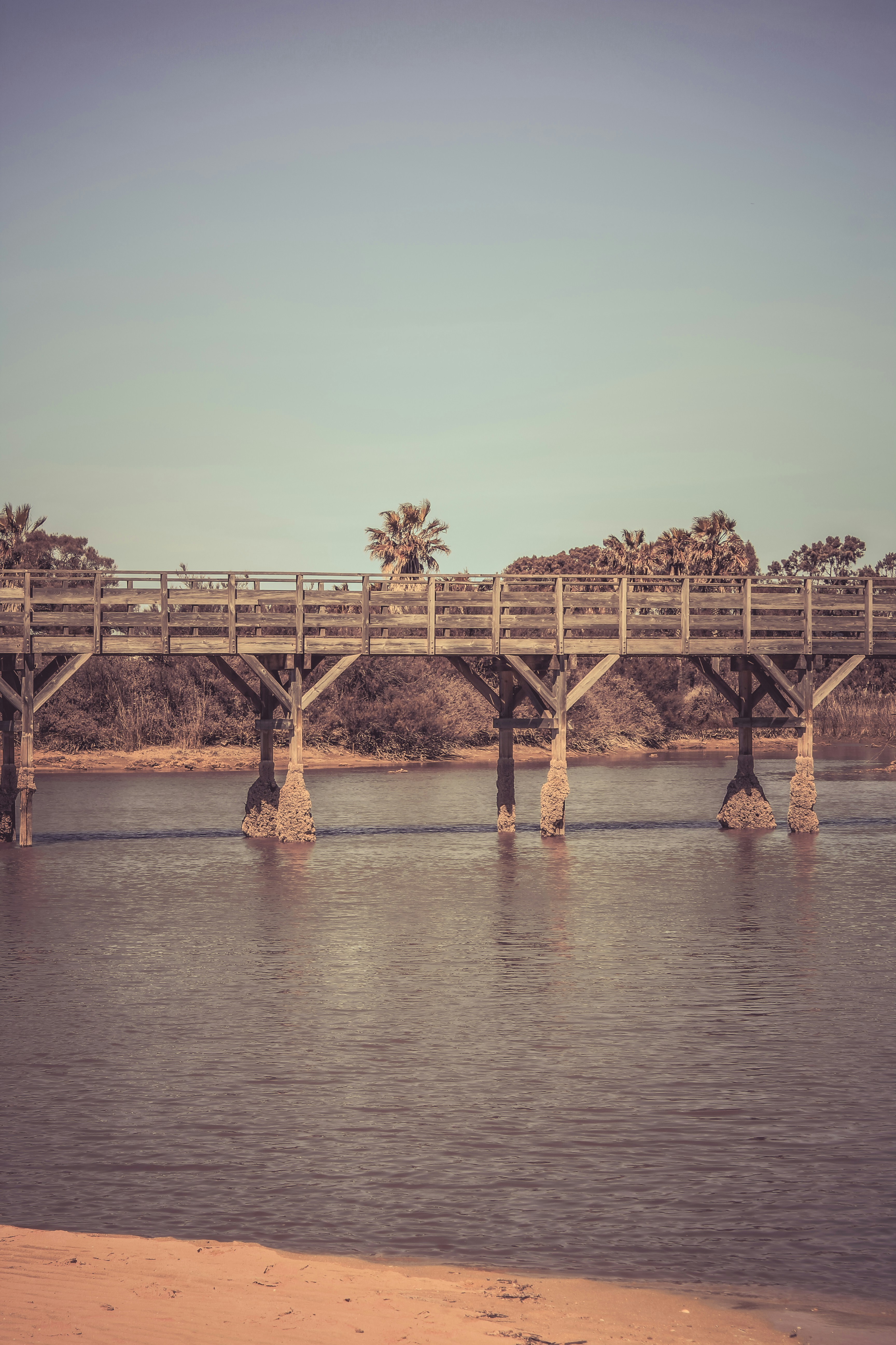 Pier at Dusk: Timber Beams Reaching Over Calmed Waters