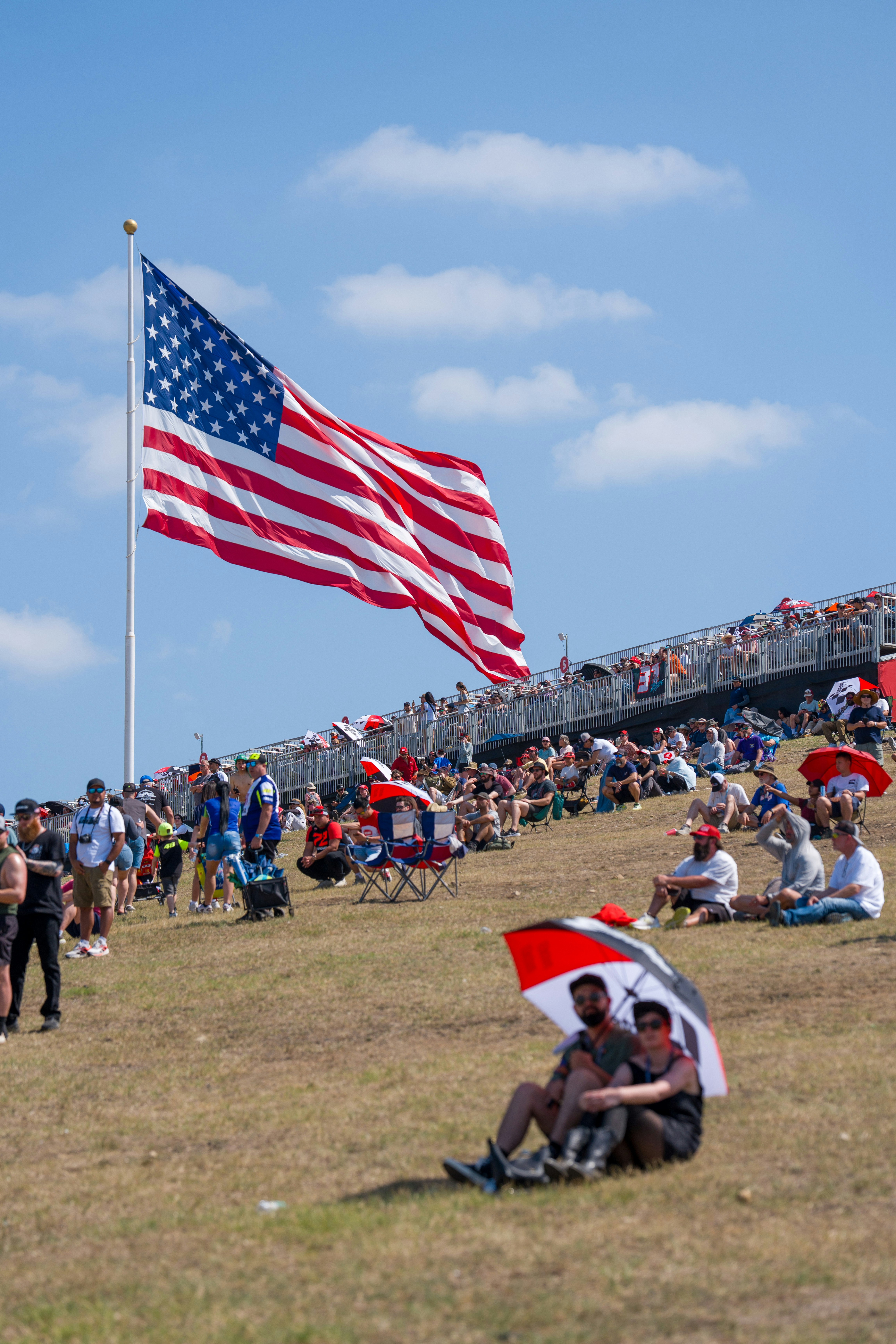 Flag over the hillside: a crowded field beneath a fluttering banner