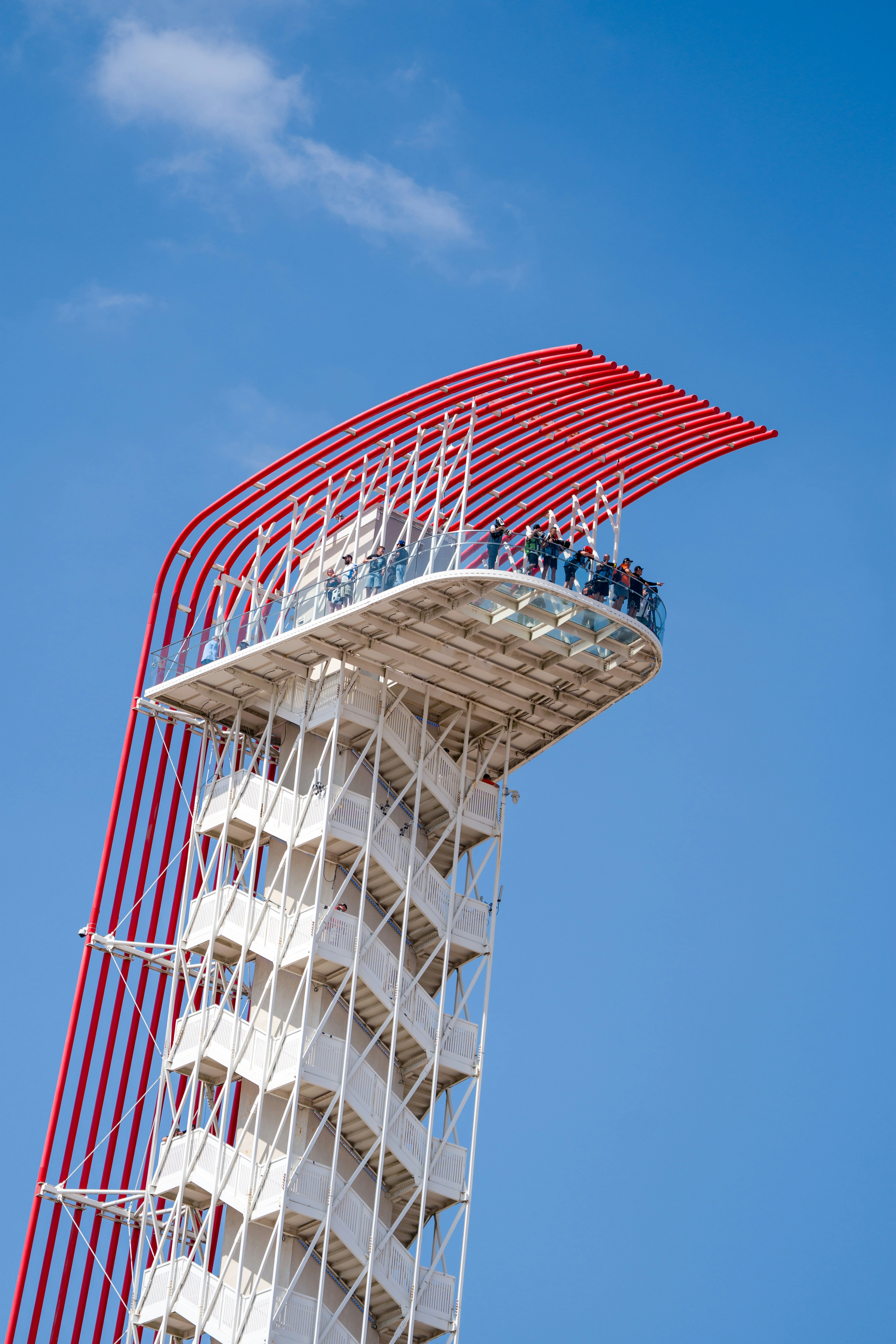 Red-ribboned ascent: atop the spiraling observation tower under a clear blue sky