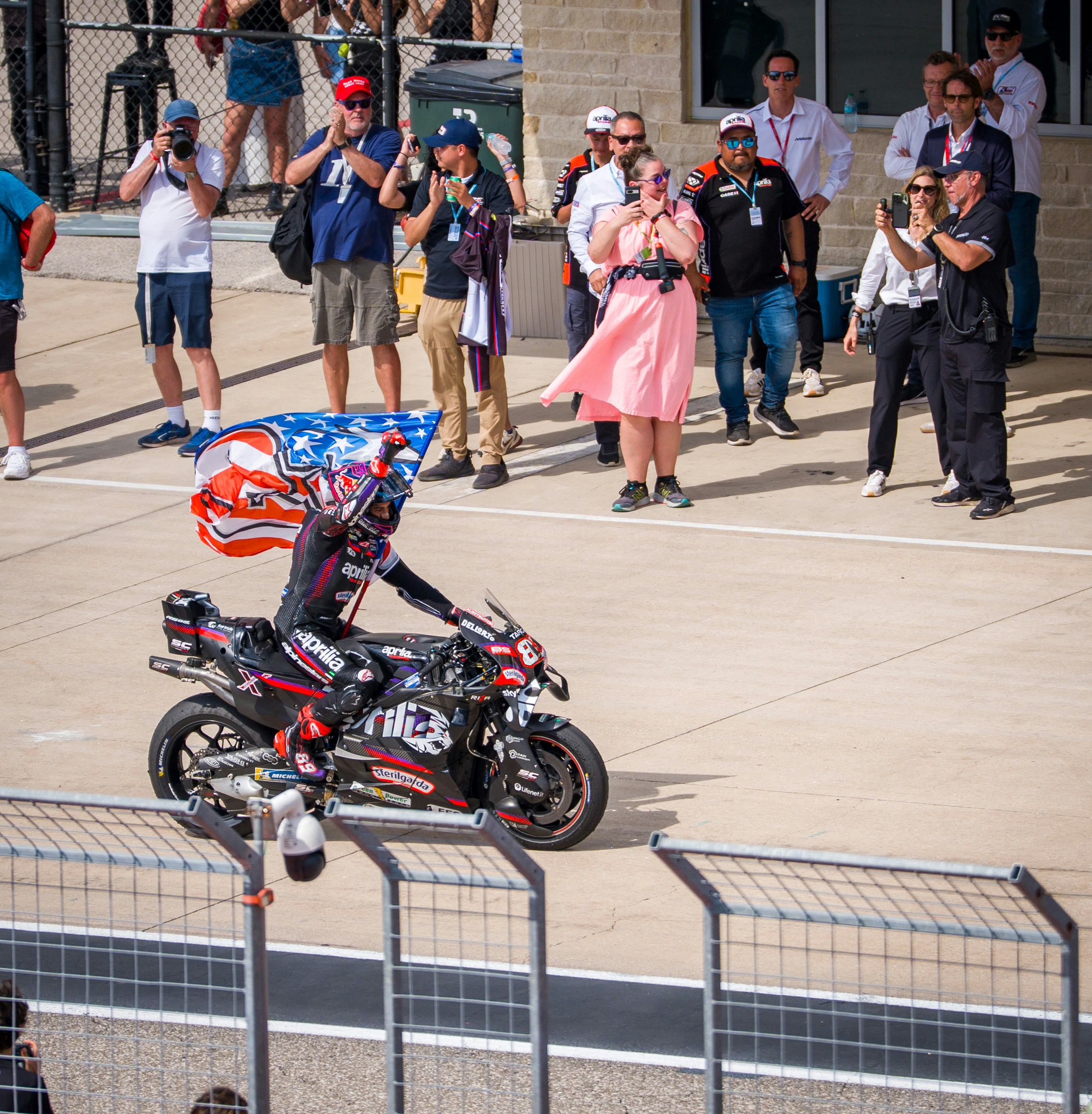 Flag-waving Rider: A Race Day Moment at the Pits