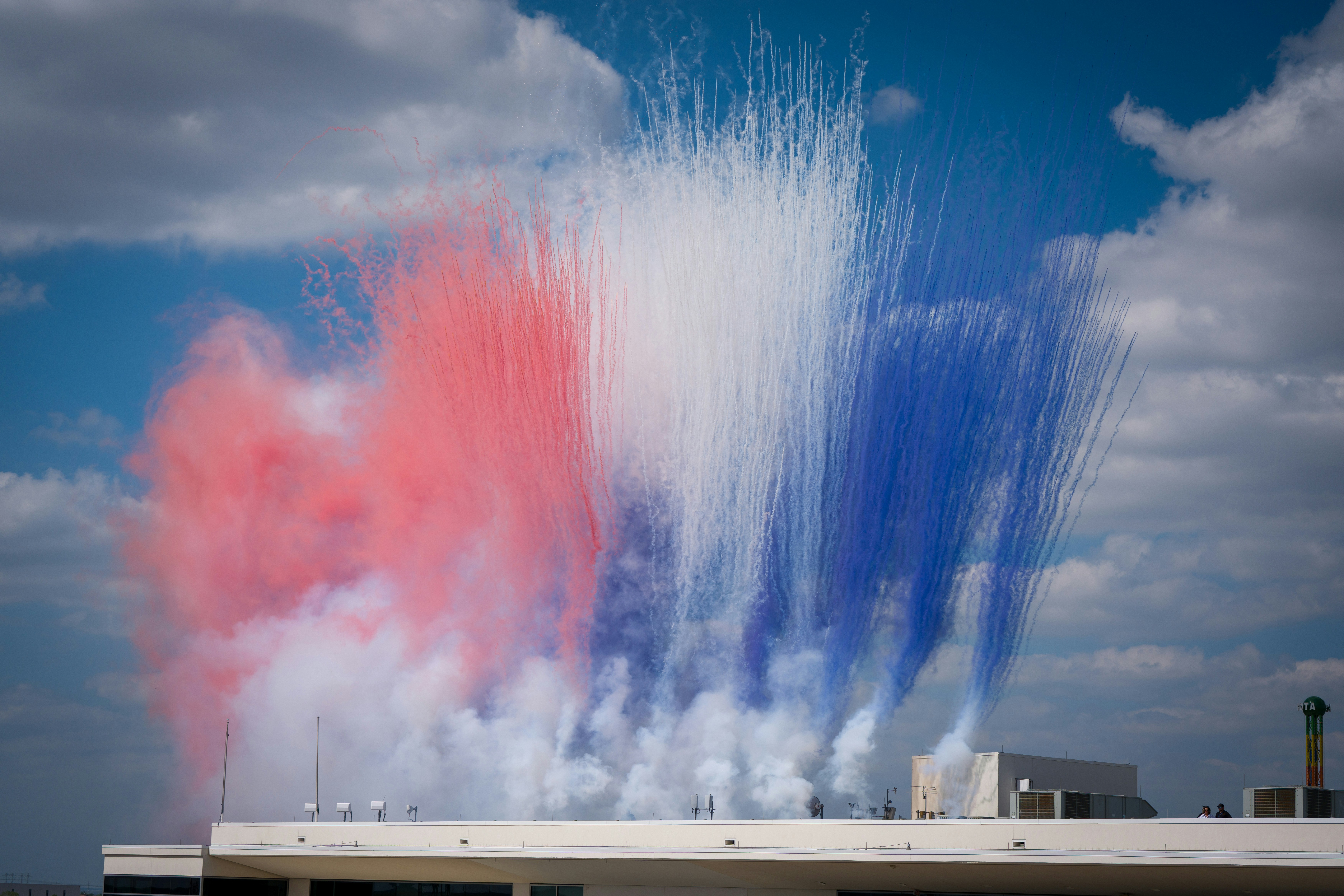 Color Smoke Ascends: A Trio of Firework Clouds Over a Flat Rooftop