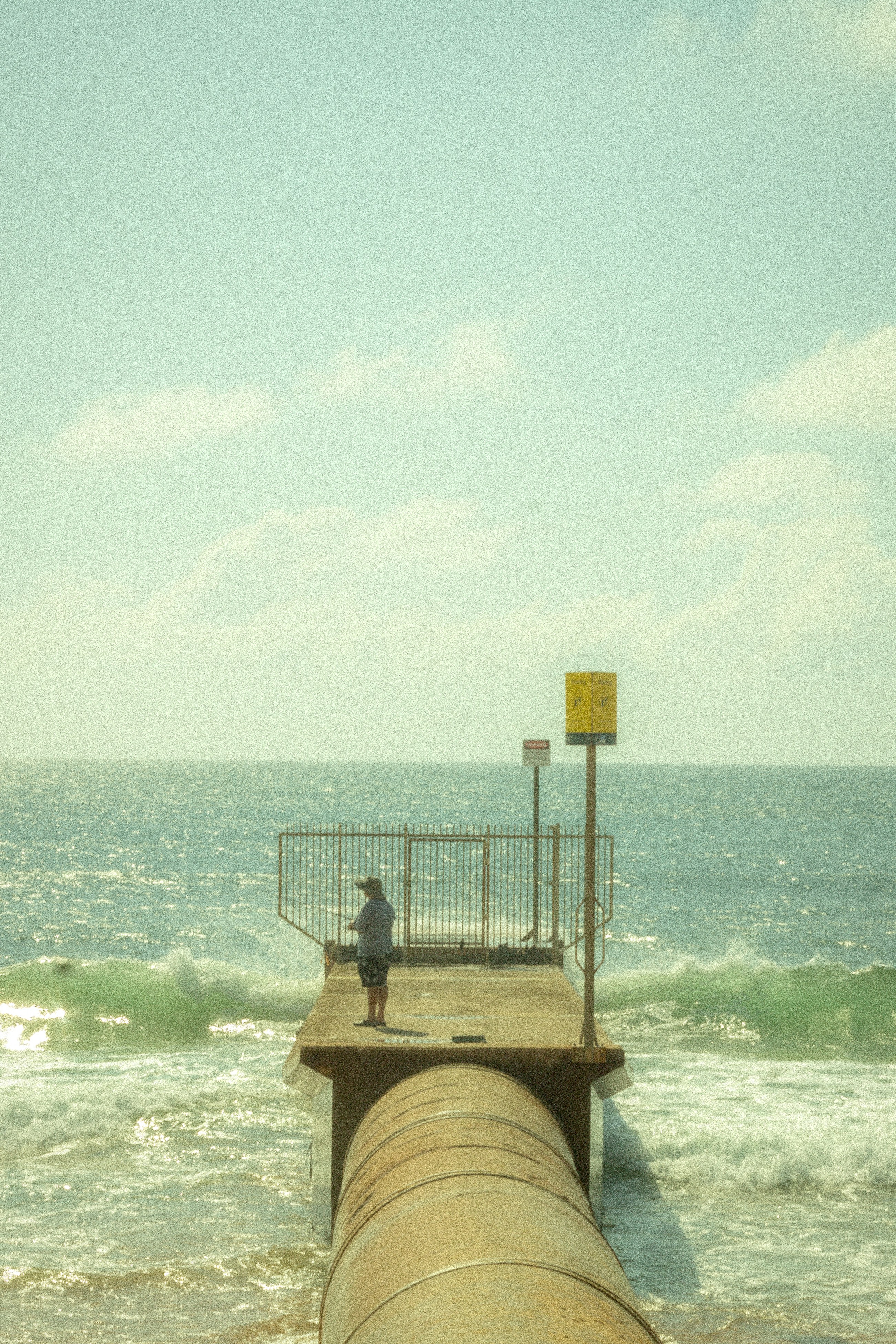 A Lone Fisherman at the End of the Pier