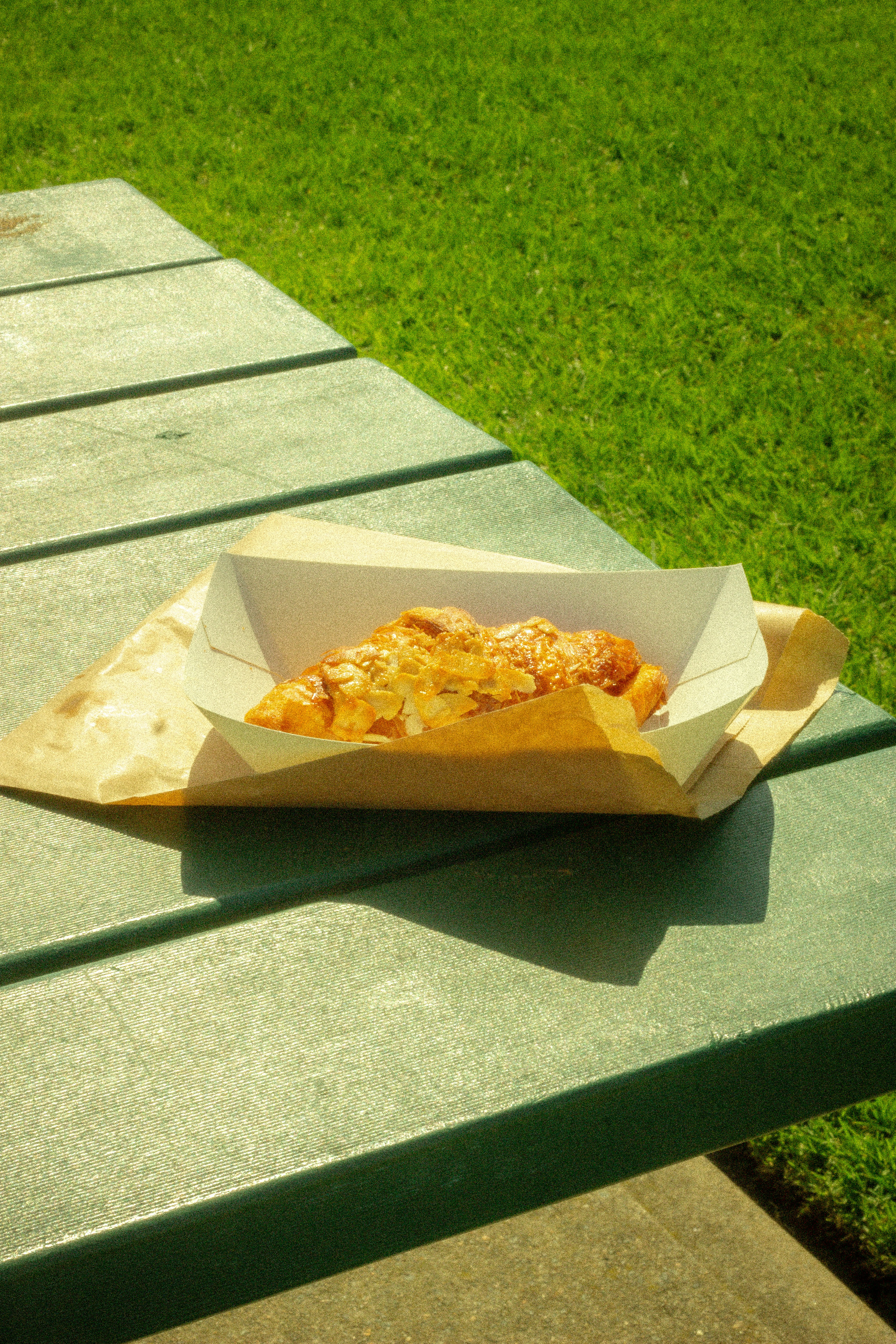 Snack on a Sunny Picnic: Crispy Pastry on a Green Bench