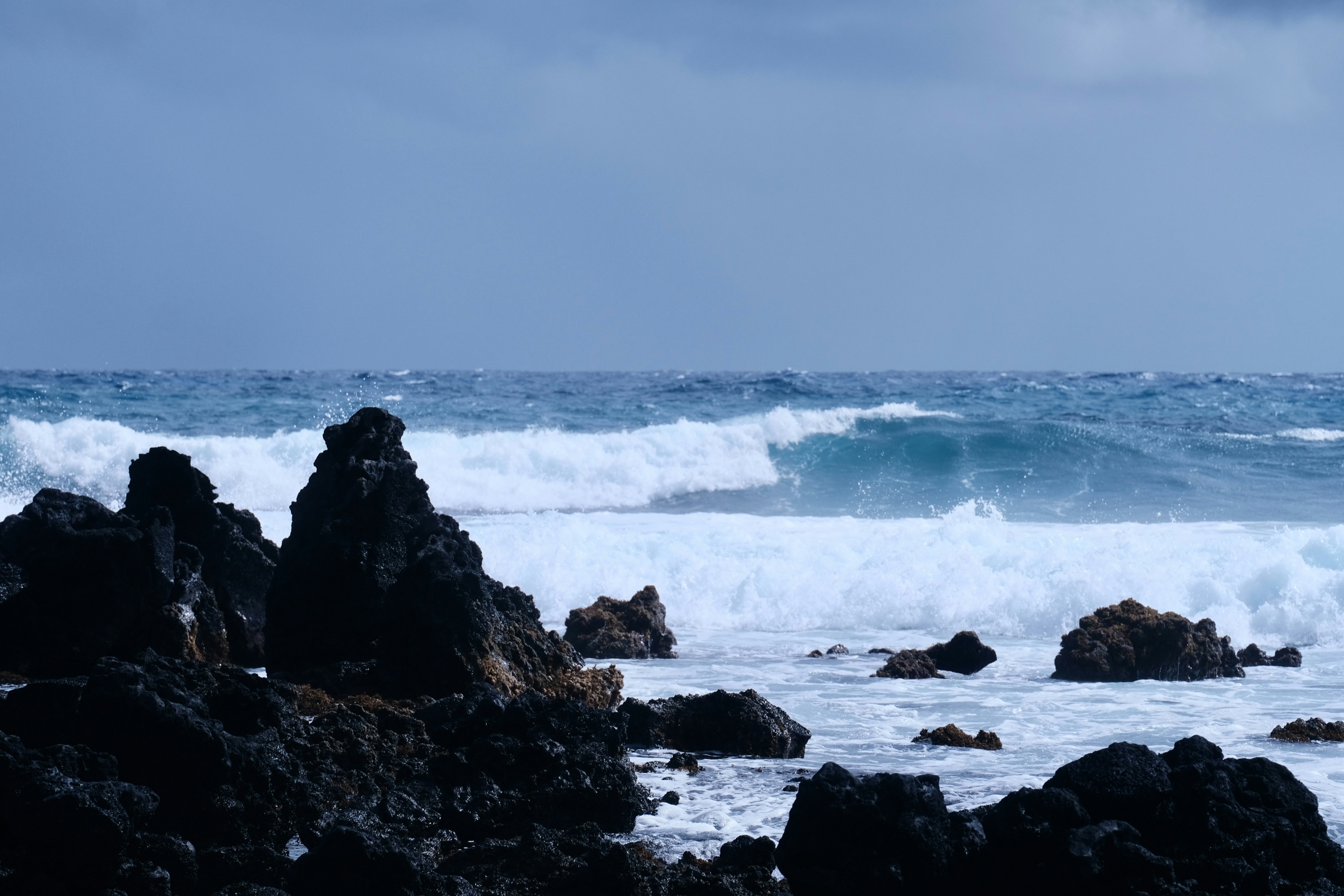 Coastal Break: A Quiet Crest of Waves Among Jagged Rocks at Dusk