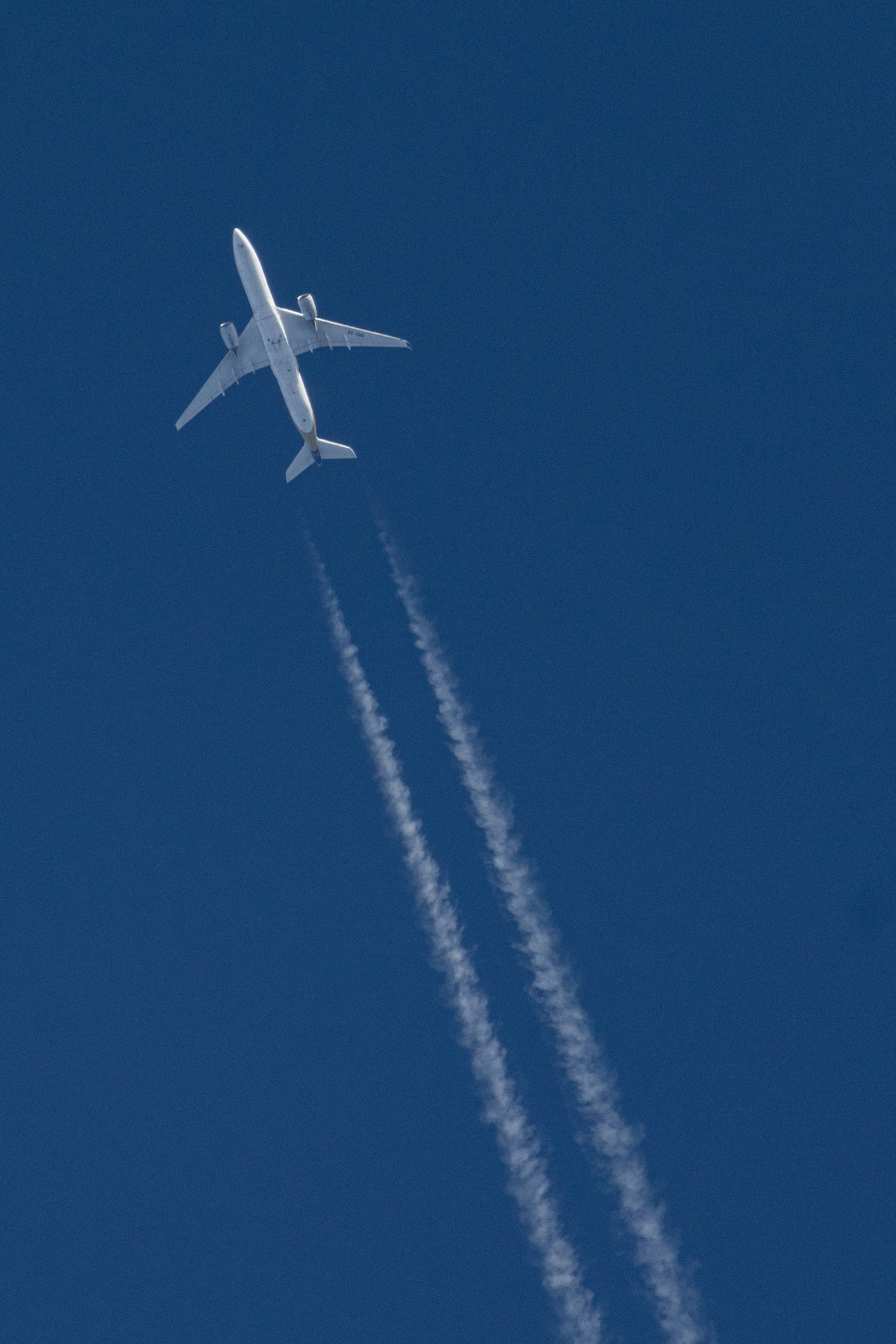 Jetliner Tracing Twin Vapor Trails Across a Clear Sky
