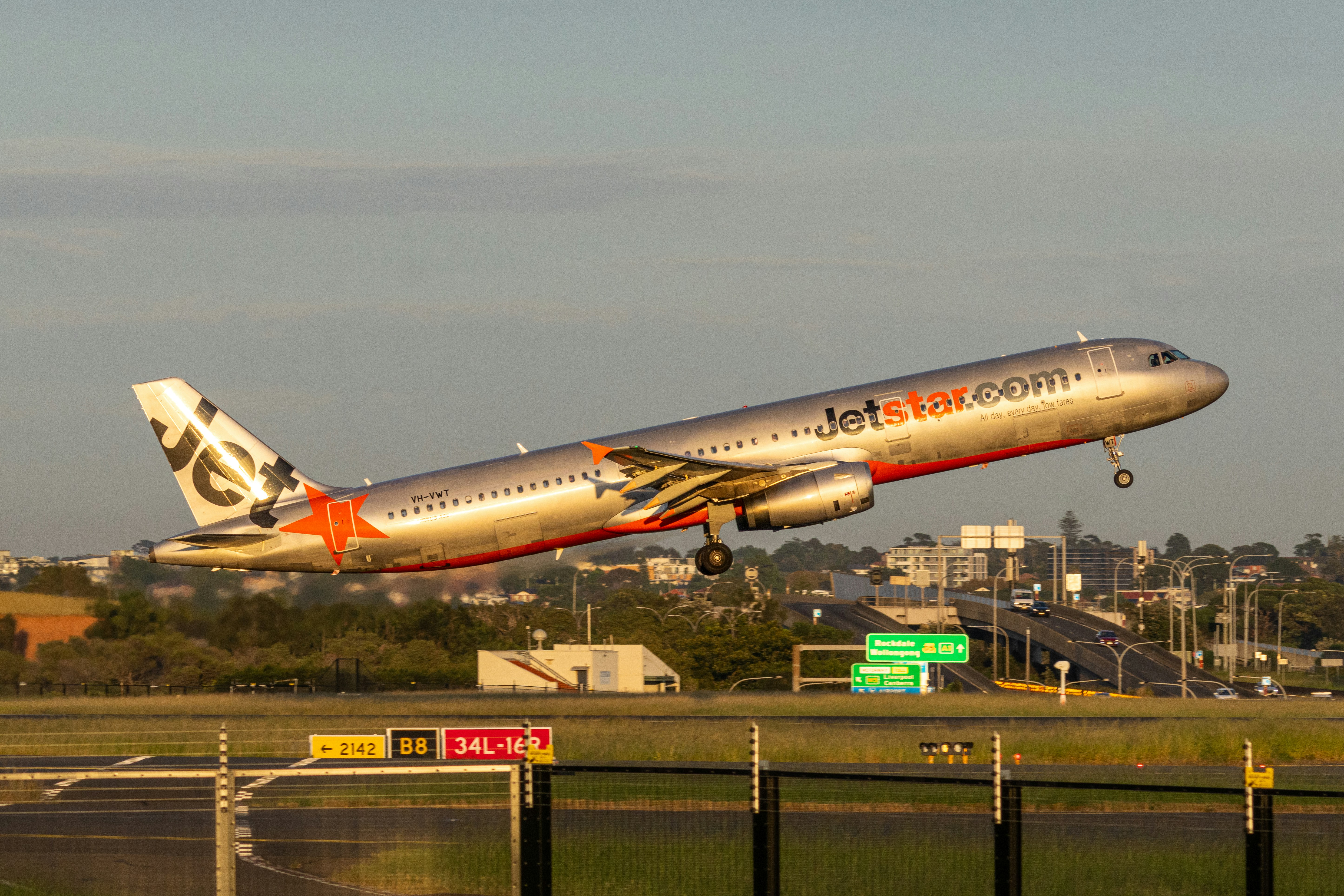 Jetstar Leap: A Narrow-Body Soars Over the Runway at Dusk