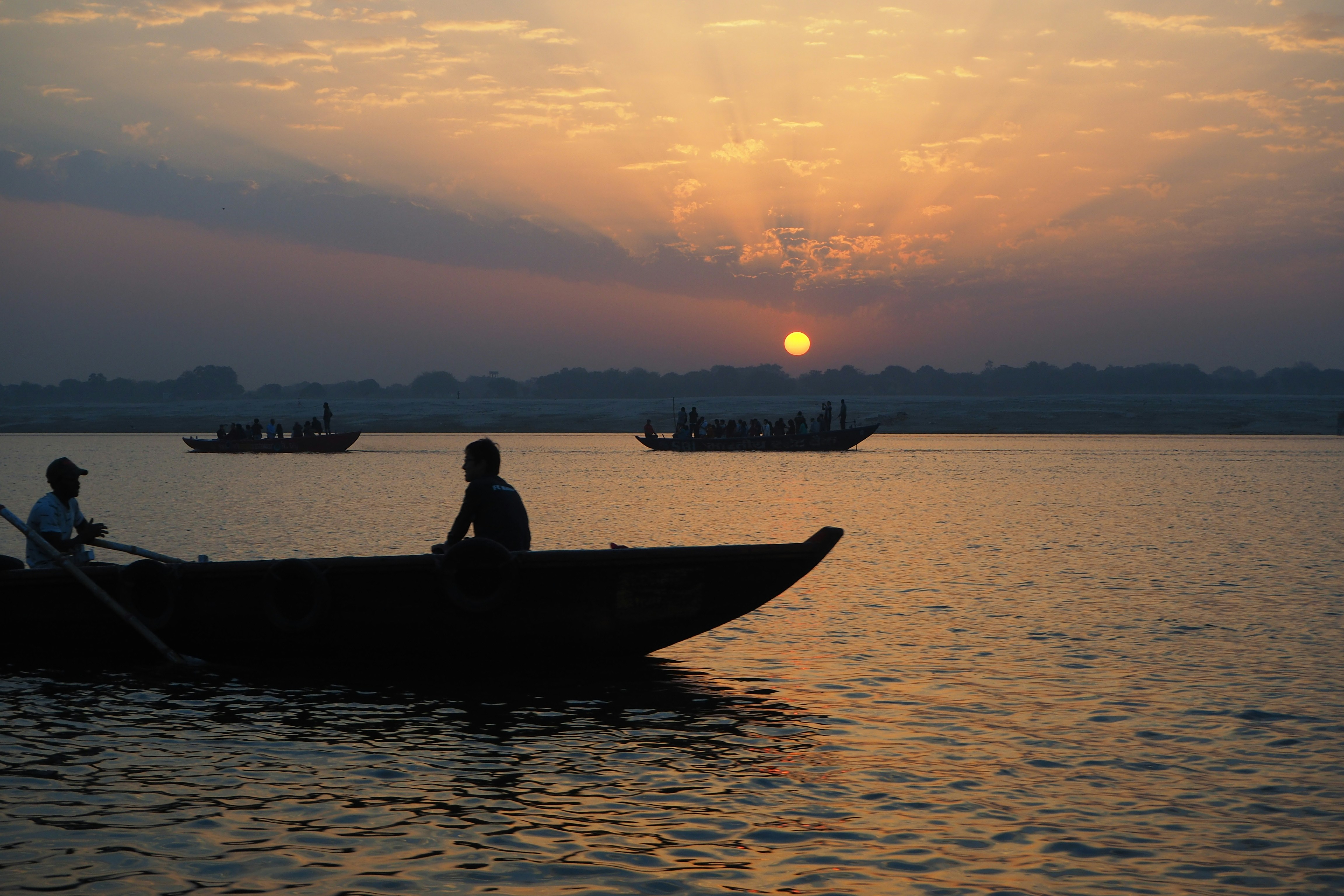 Sunset Silhouette: Boats Drifting on Calm Waters