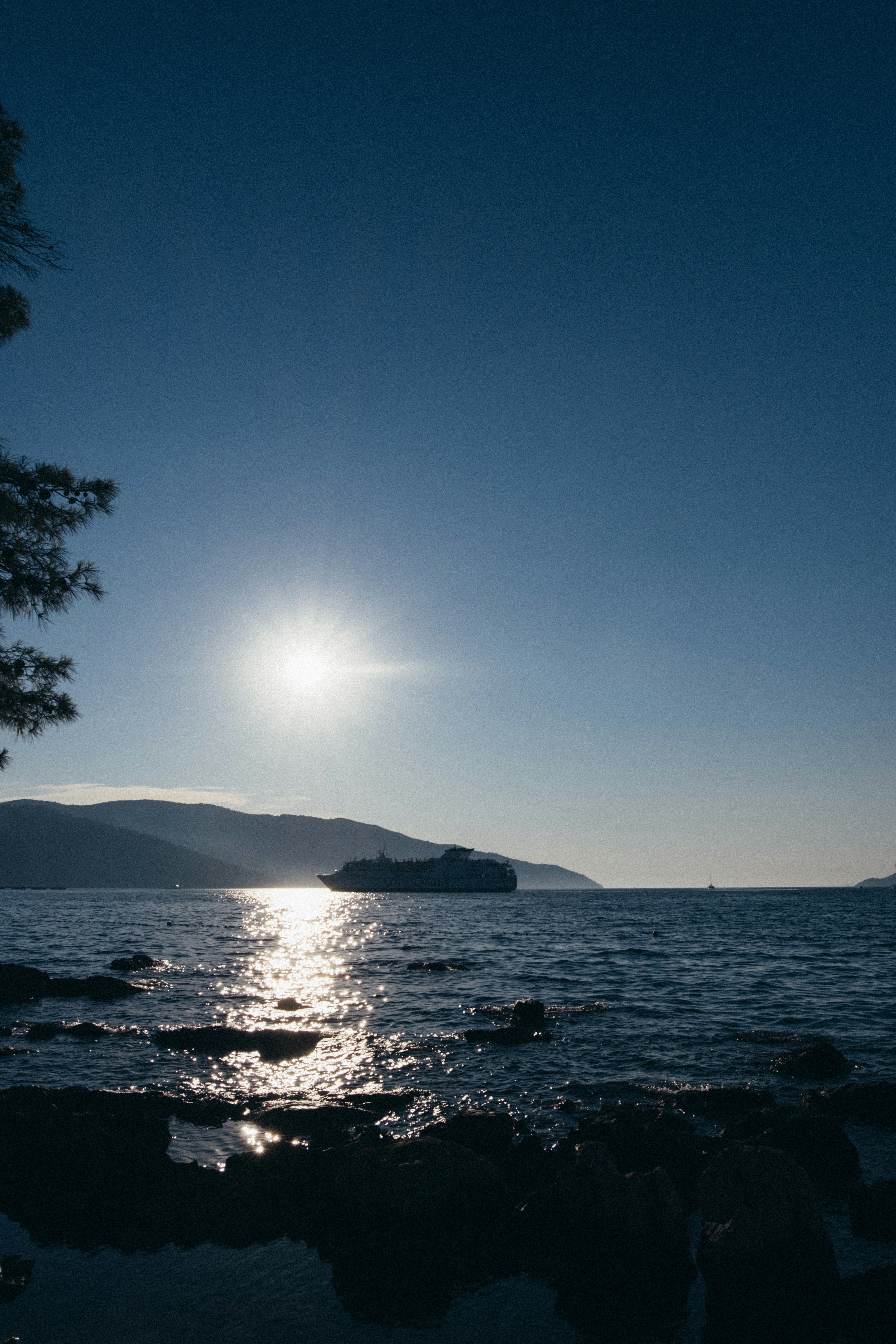 Sunlit Passage: A Sailboat Quietly Crossing the Horizon