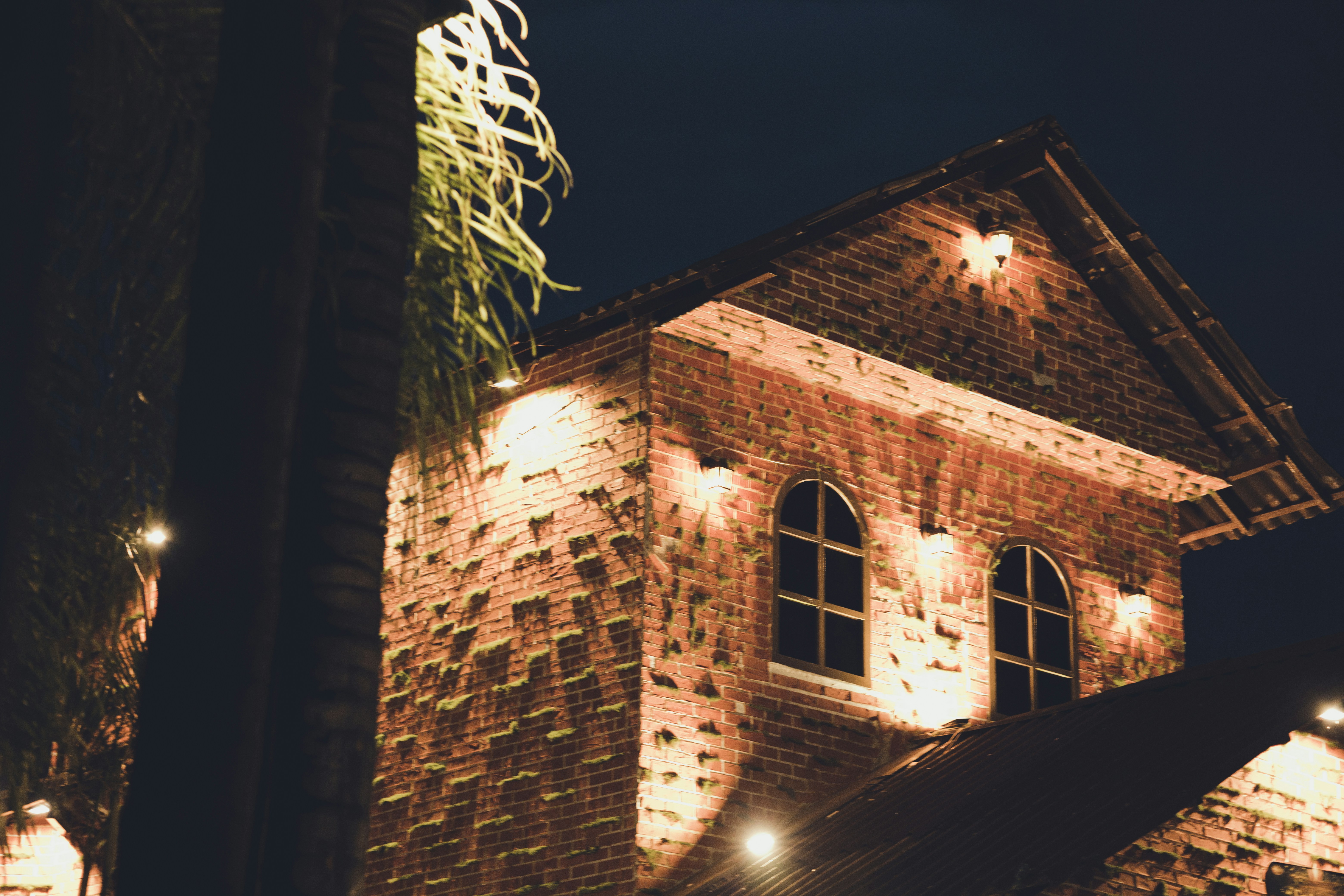 Brick Bell-Tower Glow: Nighttime Facade of a Cozy Gabled Structure