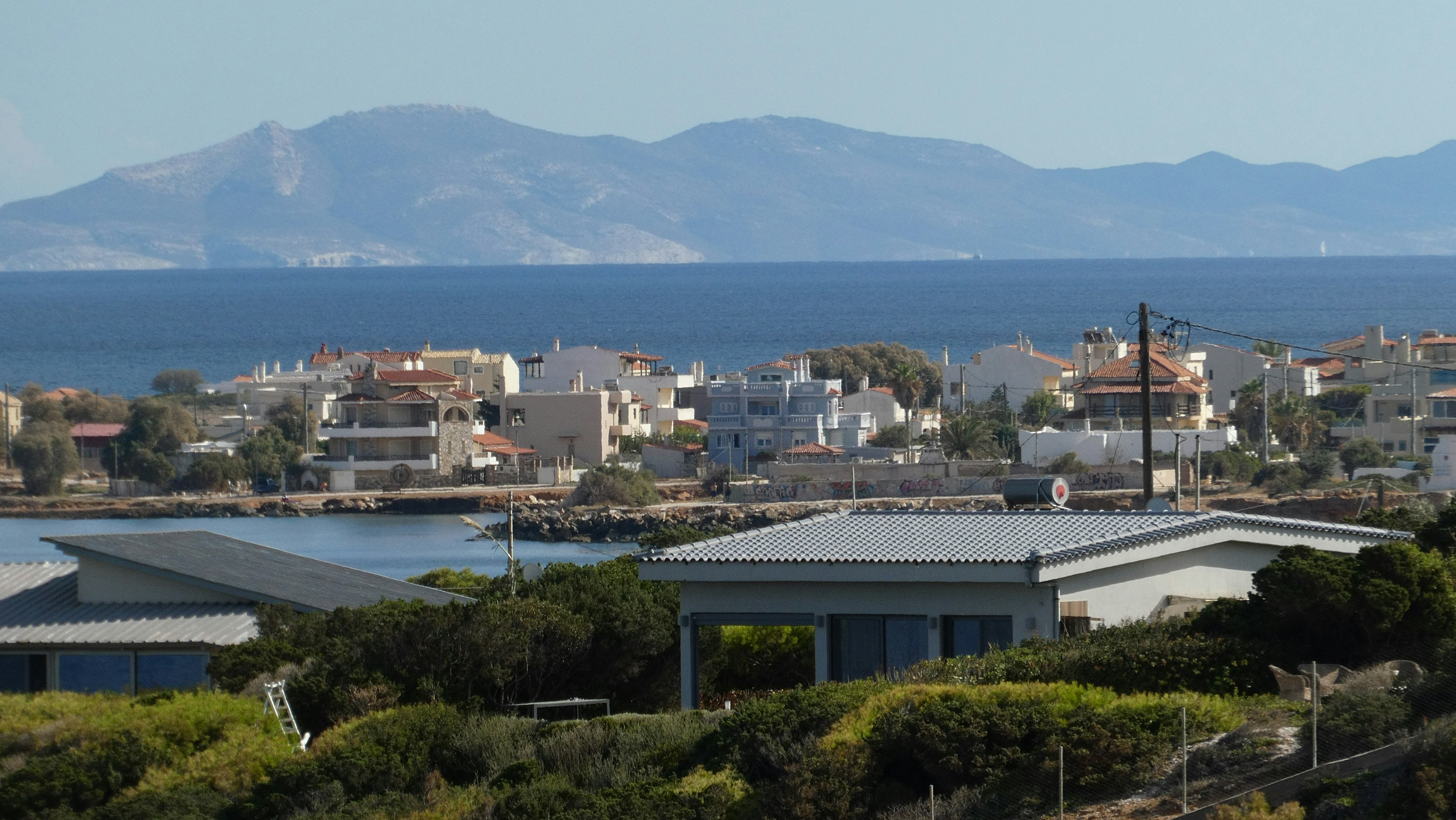 Coastal Village Horizon: Rooftops, Sea, and Distant Mountains