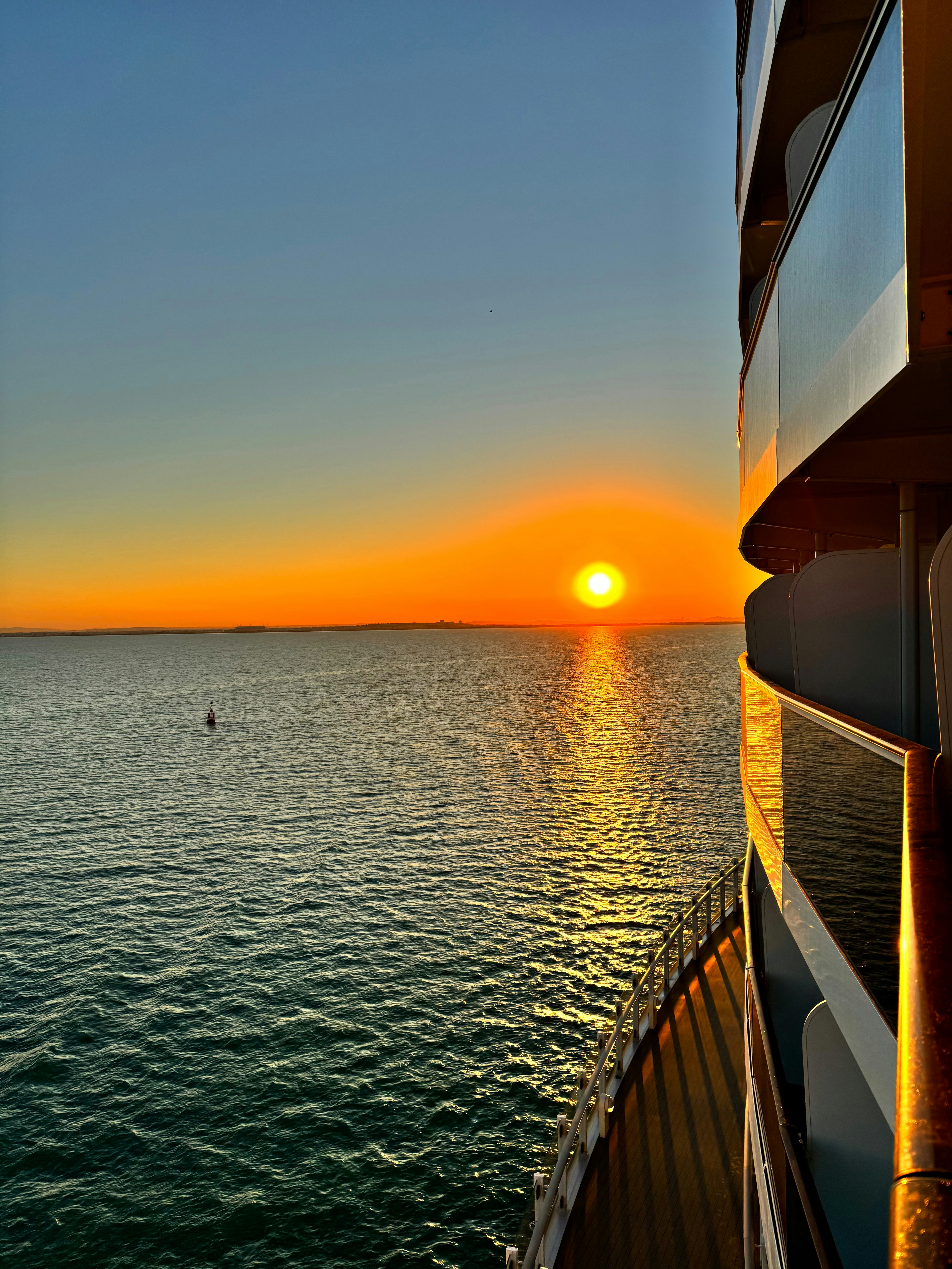 Sunset Over the Water, Reflections Gleaming from a Vessel’s Glass Facade
