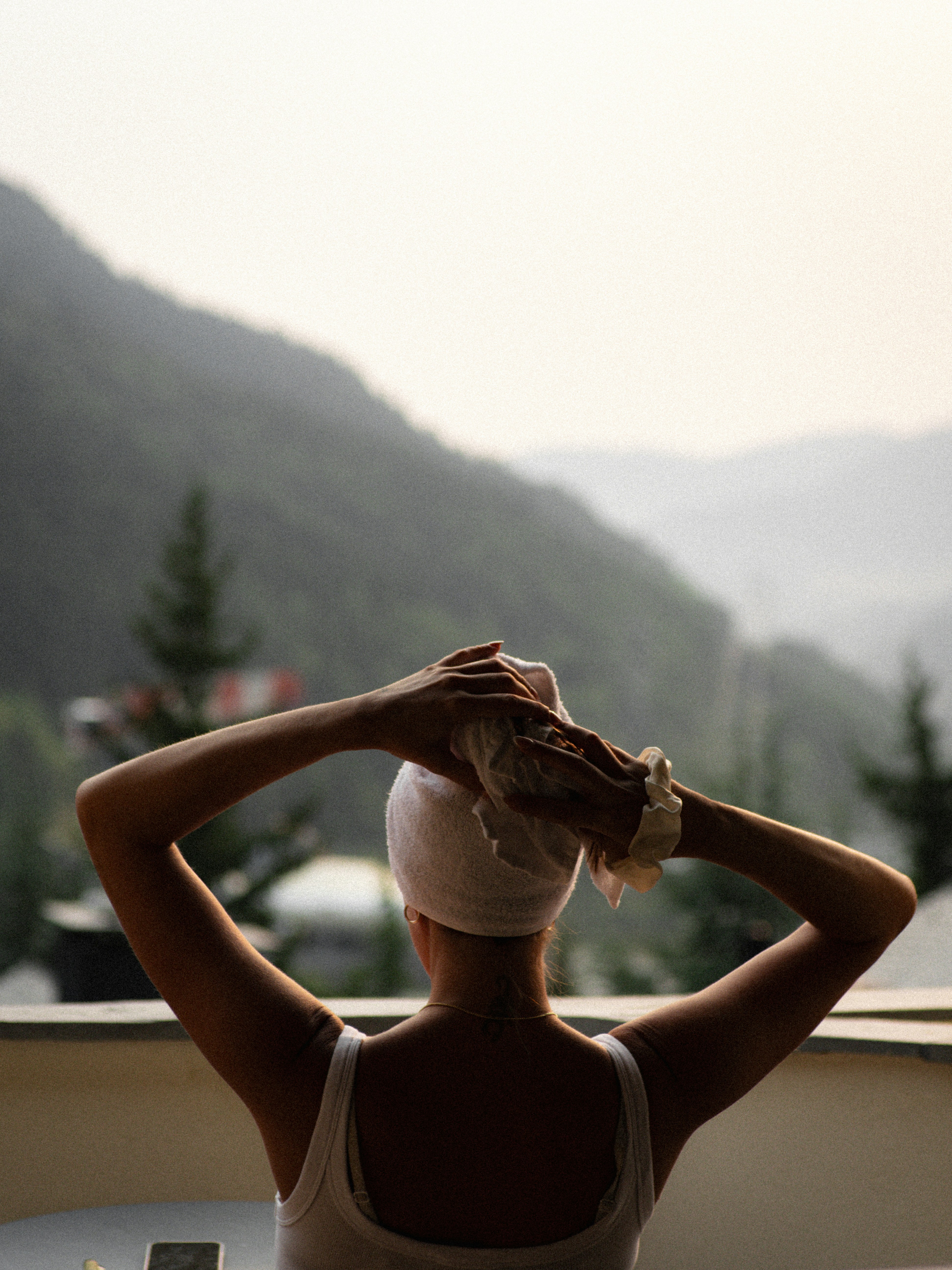 Silhouette of a Hooded Back: A Quiet Balcony Routine in the Mountains