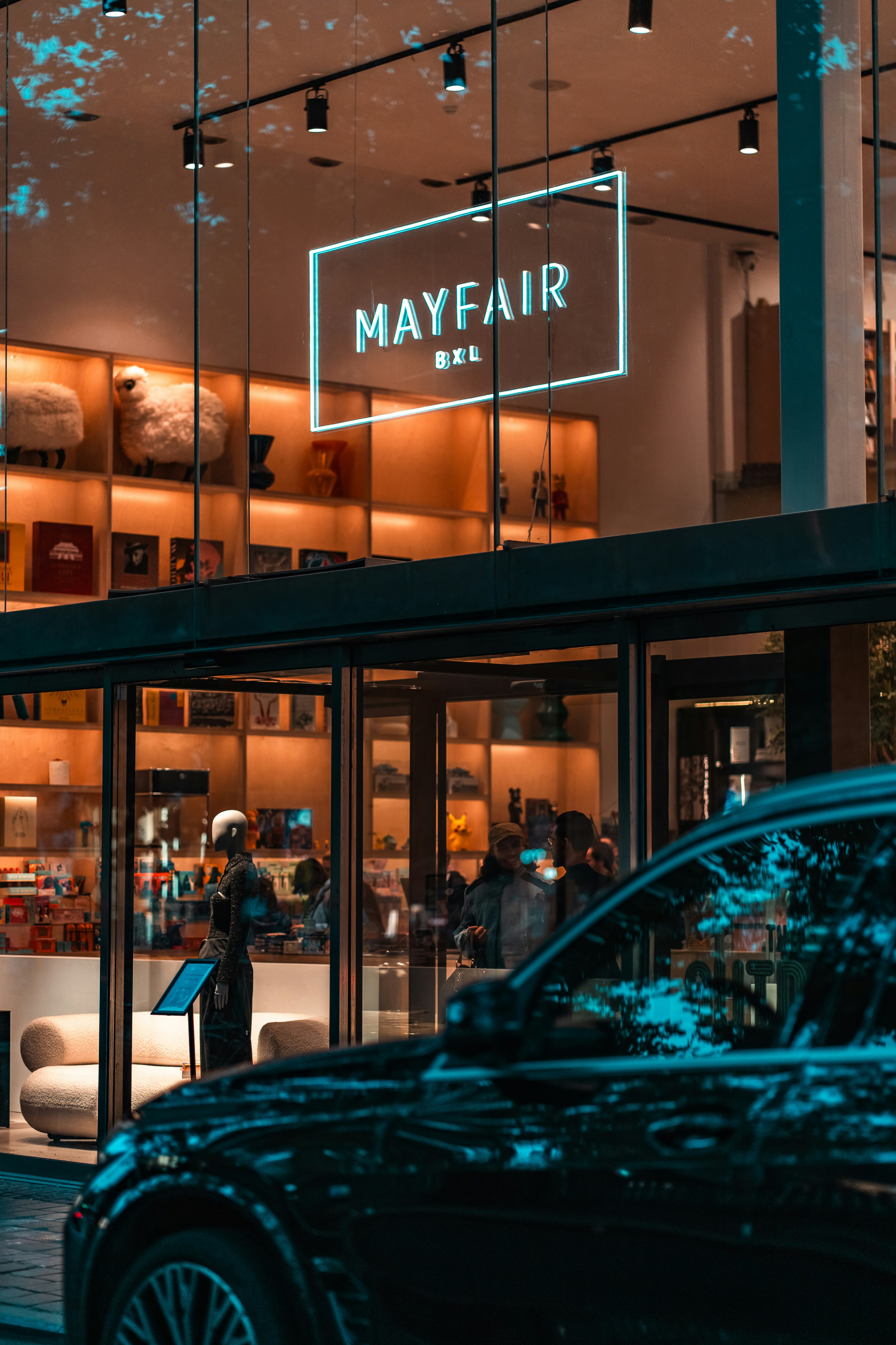 Mayfair Window: Neon Sign and Storefront Glow Across a Busy Street