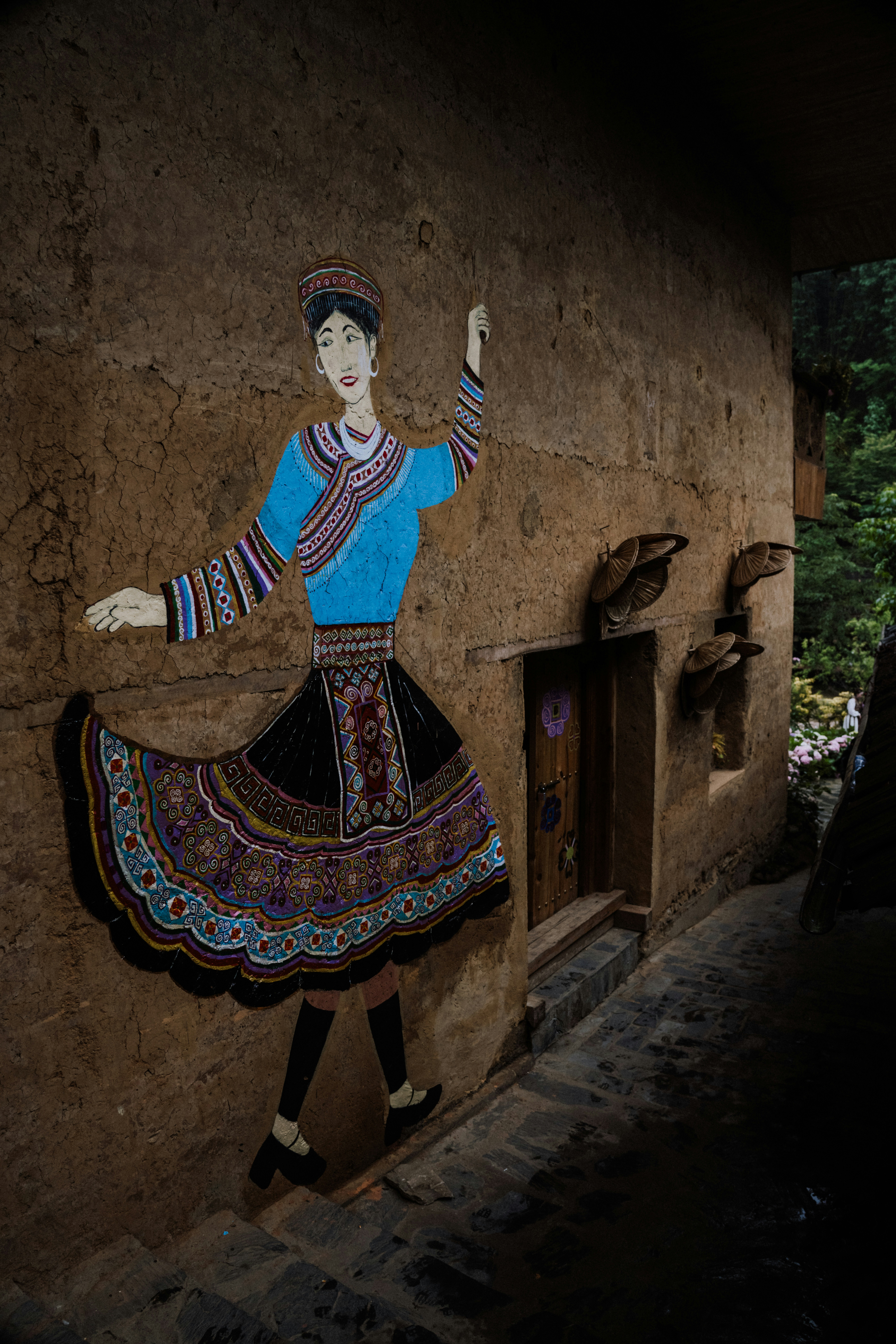 Colorful mural of a dancing woman on a sun-baked wall