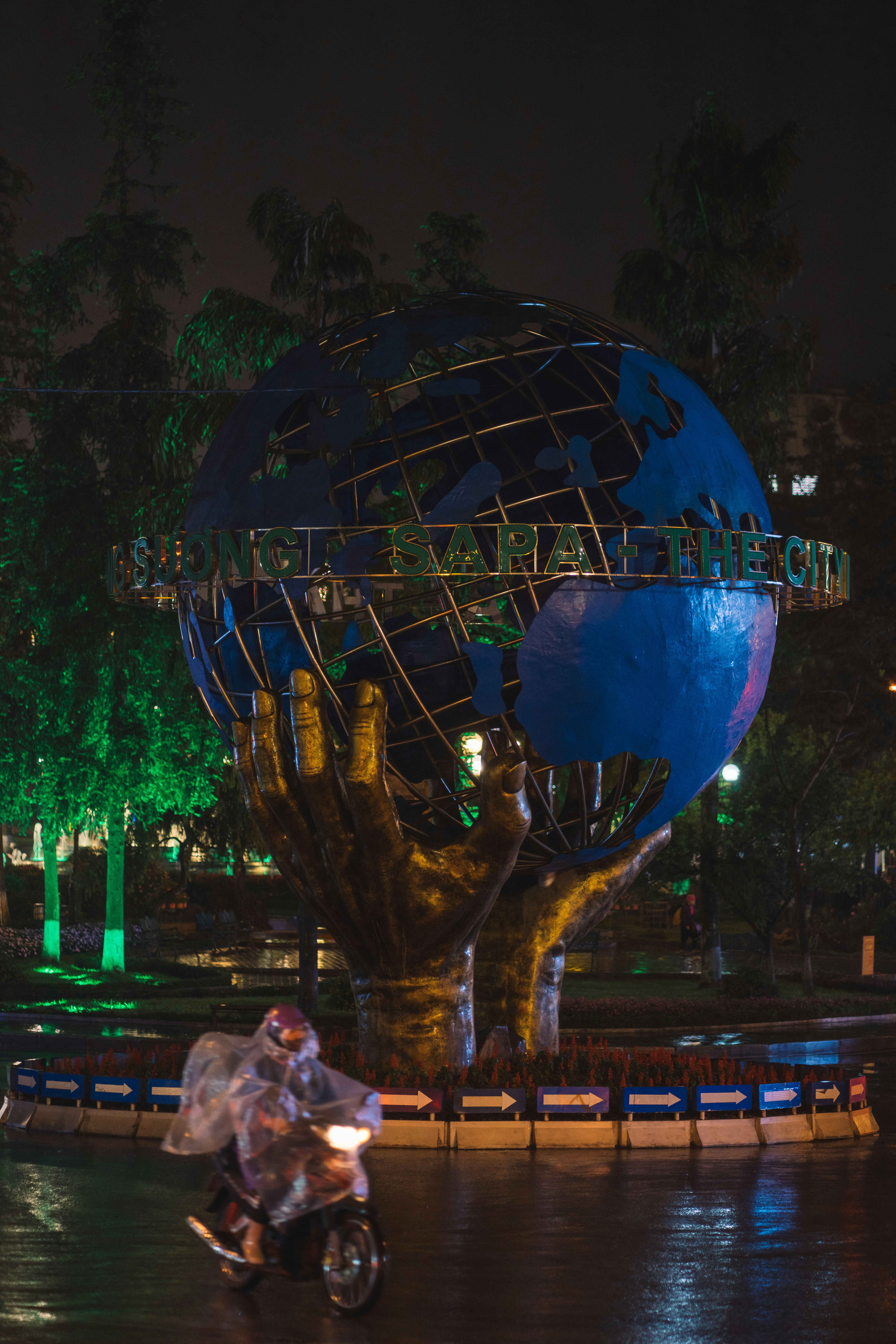 Globe of Hope: Nighttime Sculpture Surrounded by Green Neon Light