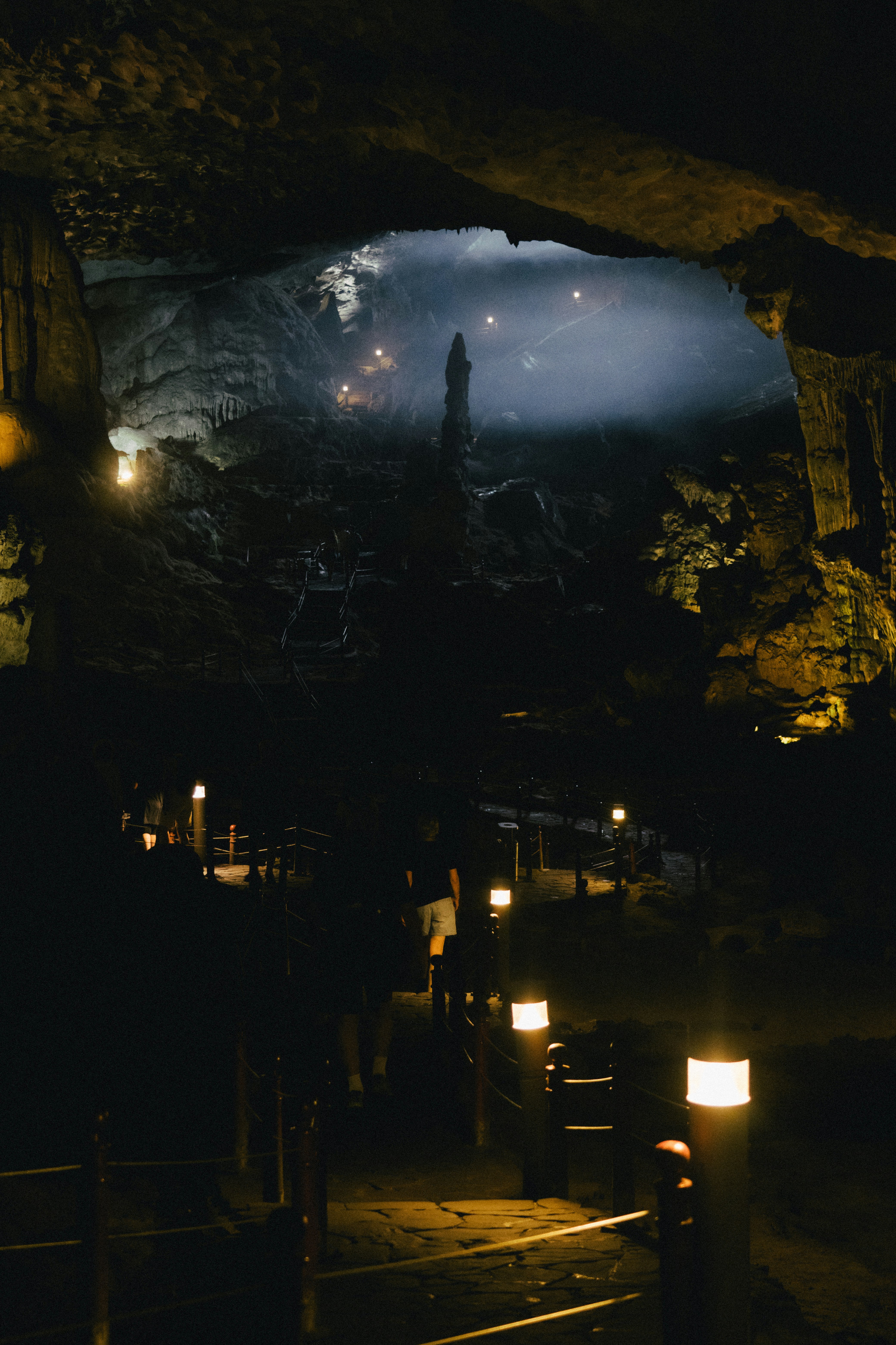 Dim Cavern Stairs Beneath a Starry Spark of Lamps