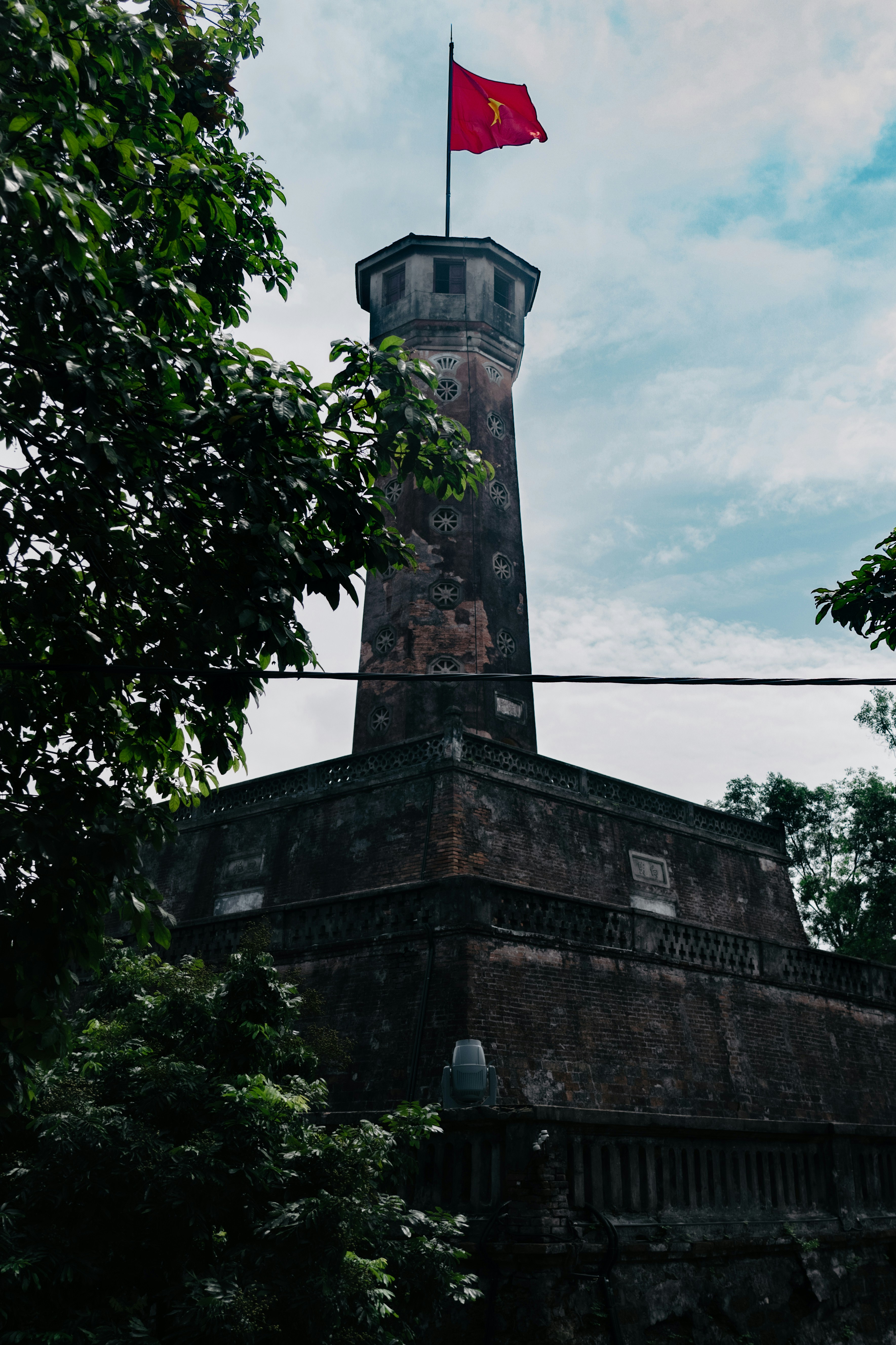 Flag atop the stone tower: quiet strength above a mossy fortress