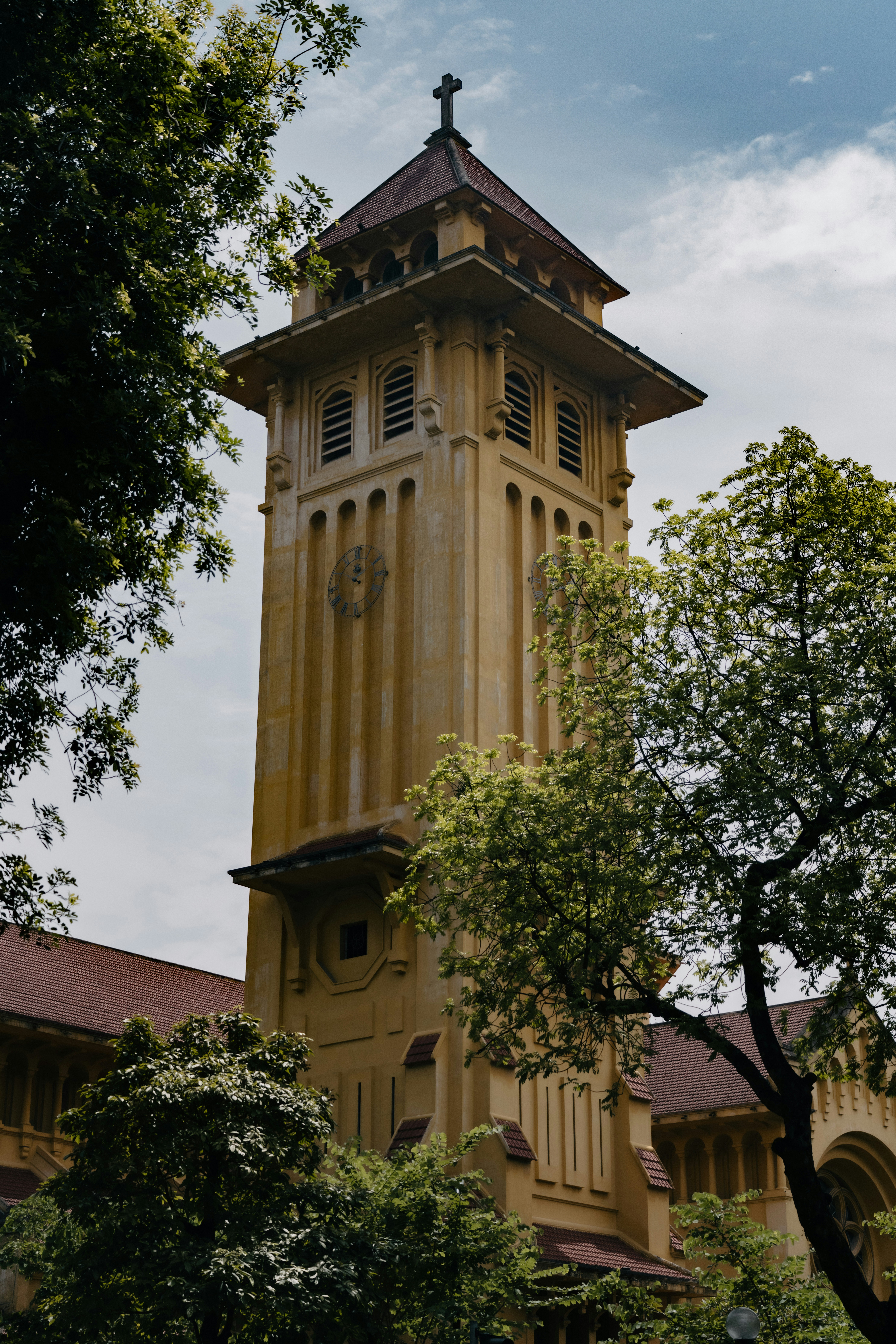 Towering Yellow Bell-Tower Amid Green Foliage