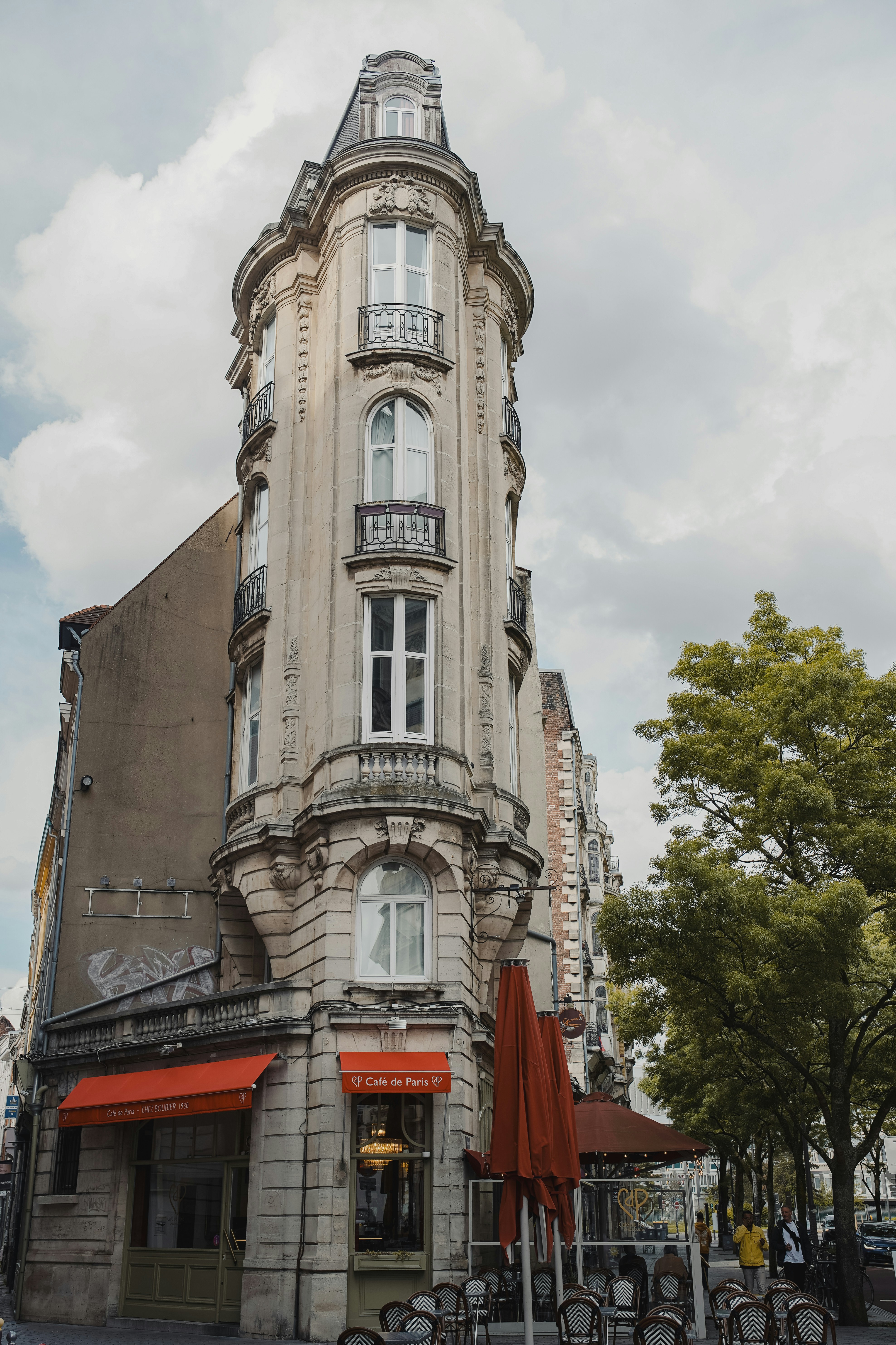 Towering Facade: A Parisian Corner edifice with café terraces