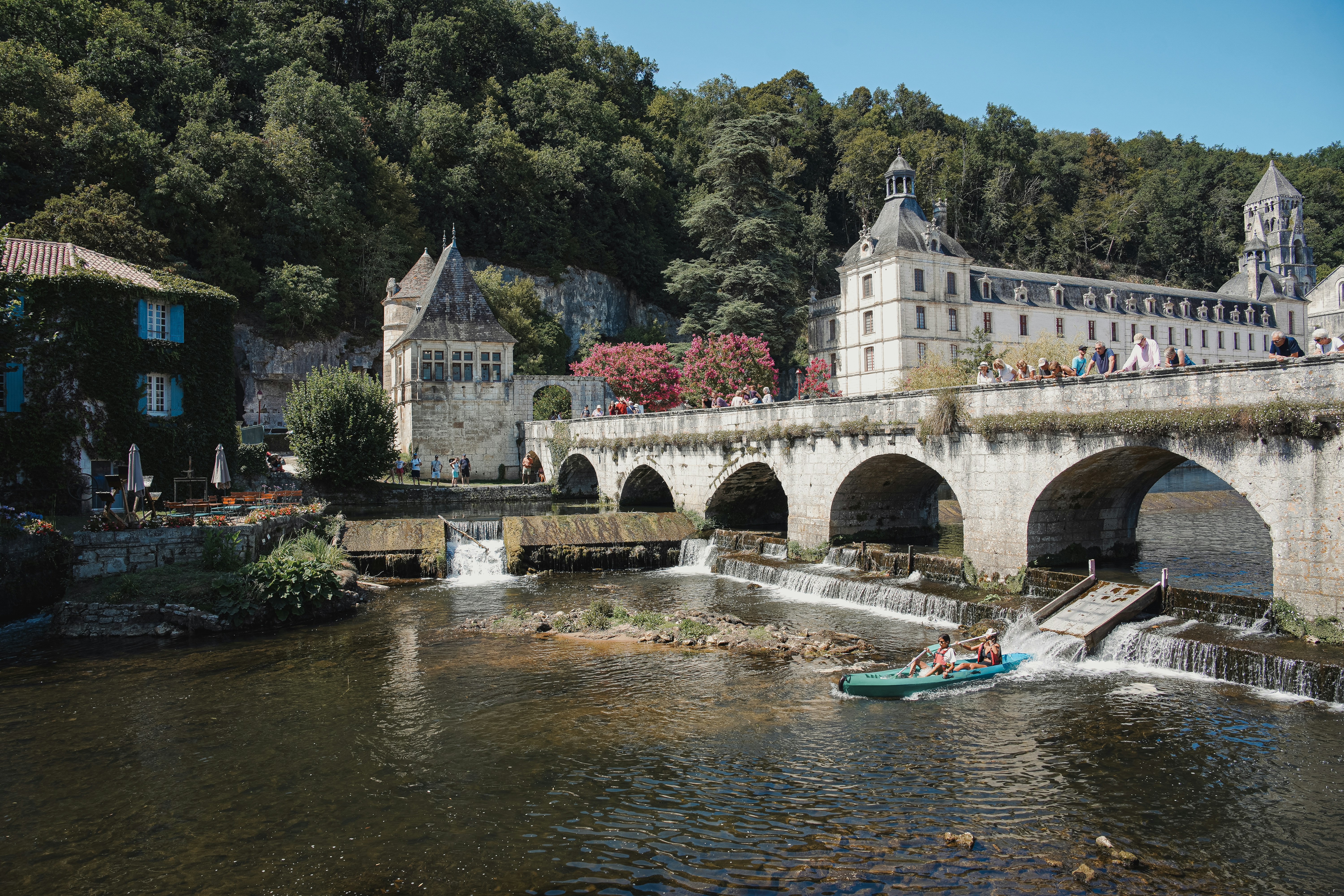 Bridge, Waterfalls, and Historic Stones: A riverside château scene