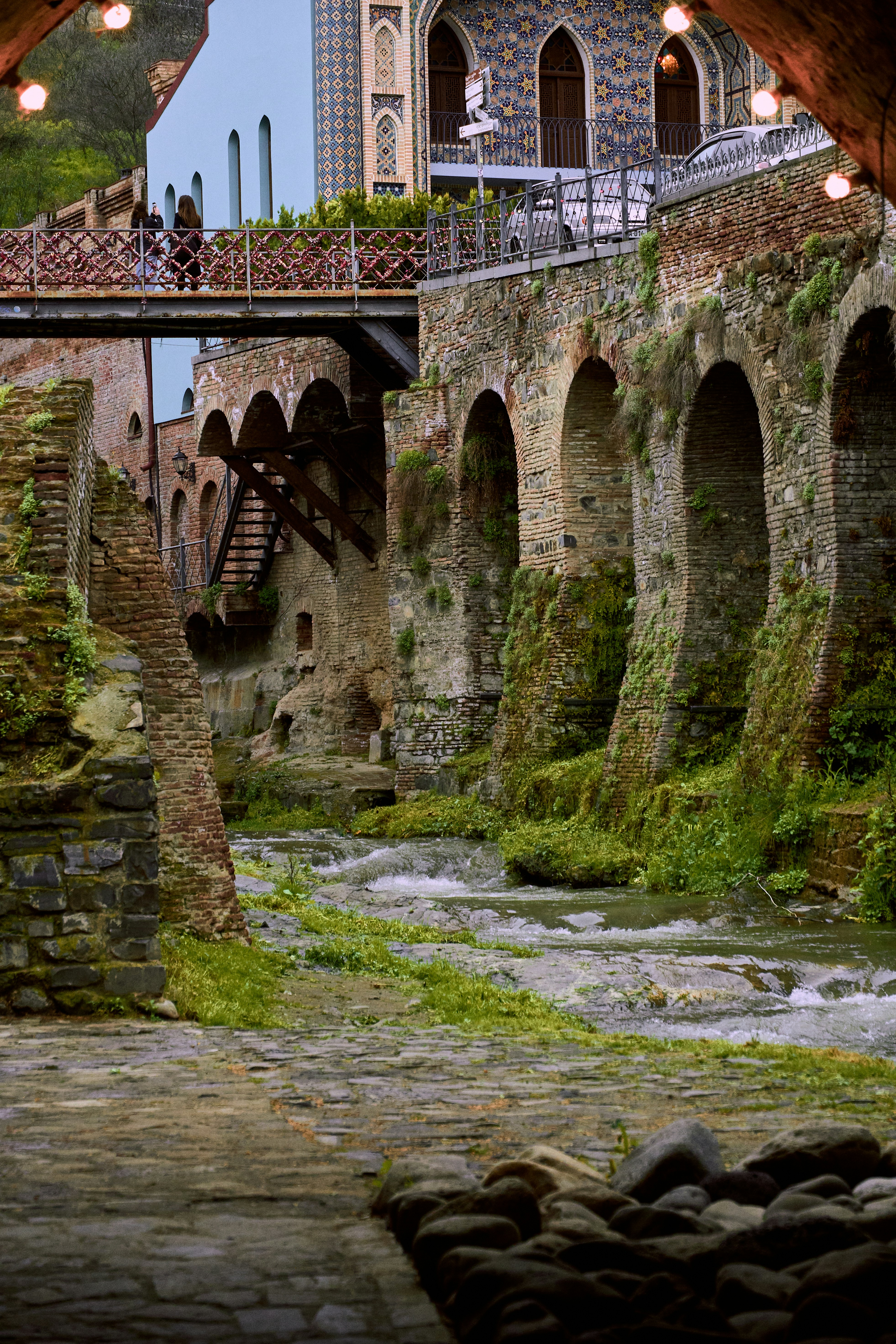 Bridge and Arcade Reflections over a Stone River Walk