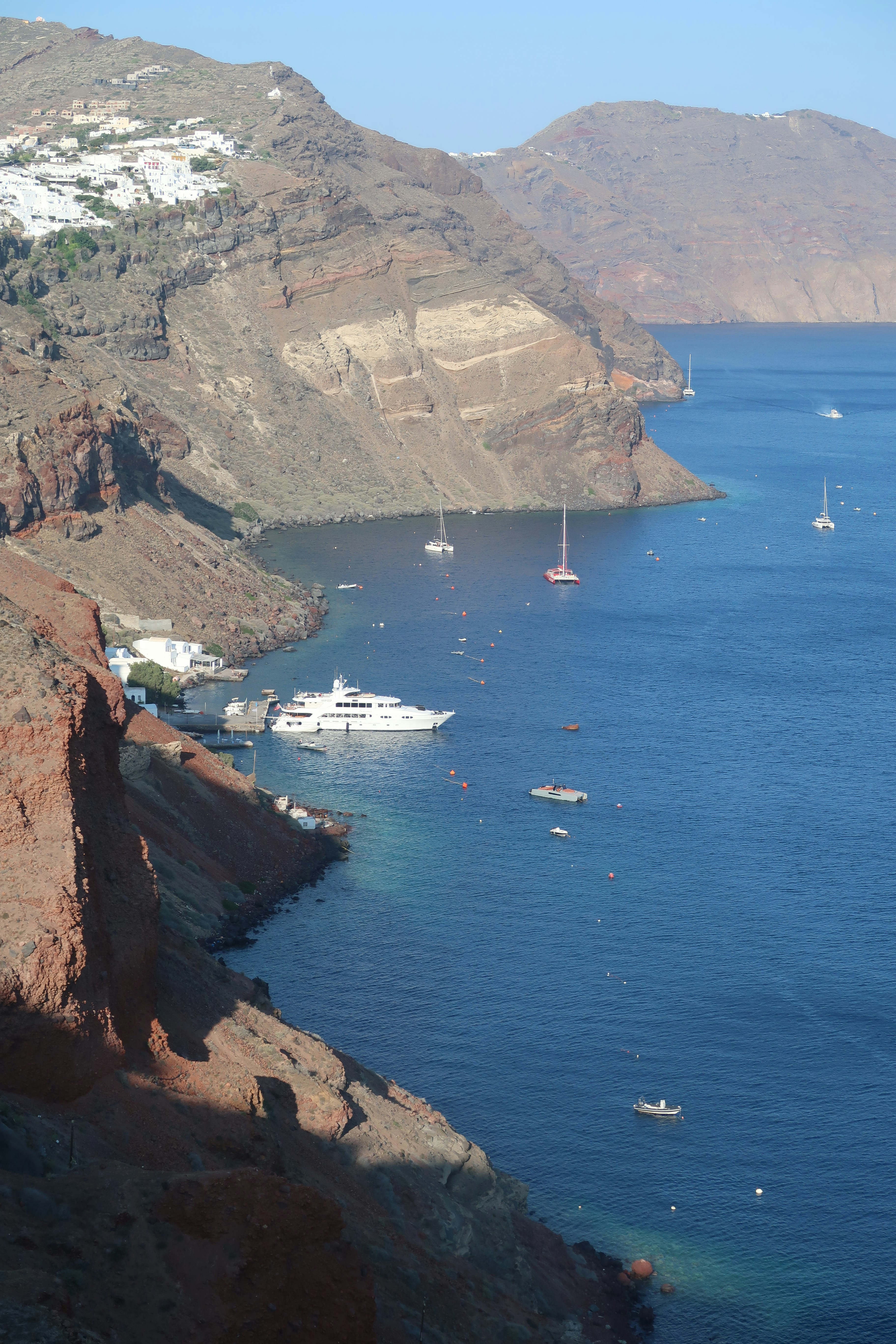 Harbor of Whitewashed Slopes: Boats Nestled Along Turquoise Edges