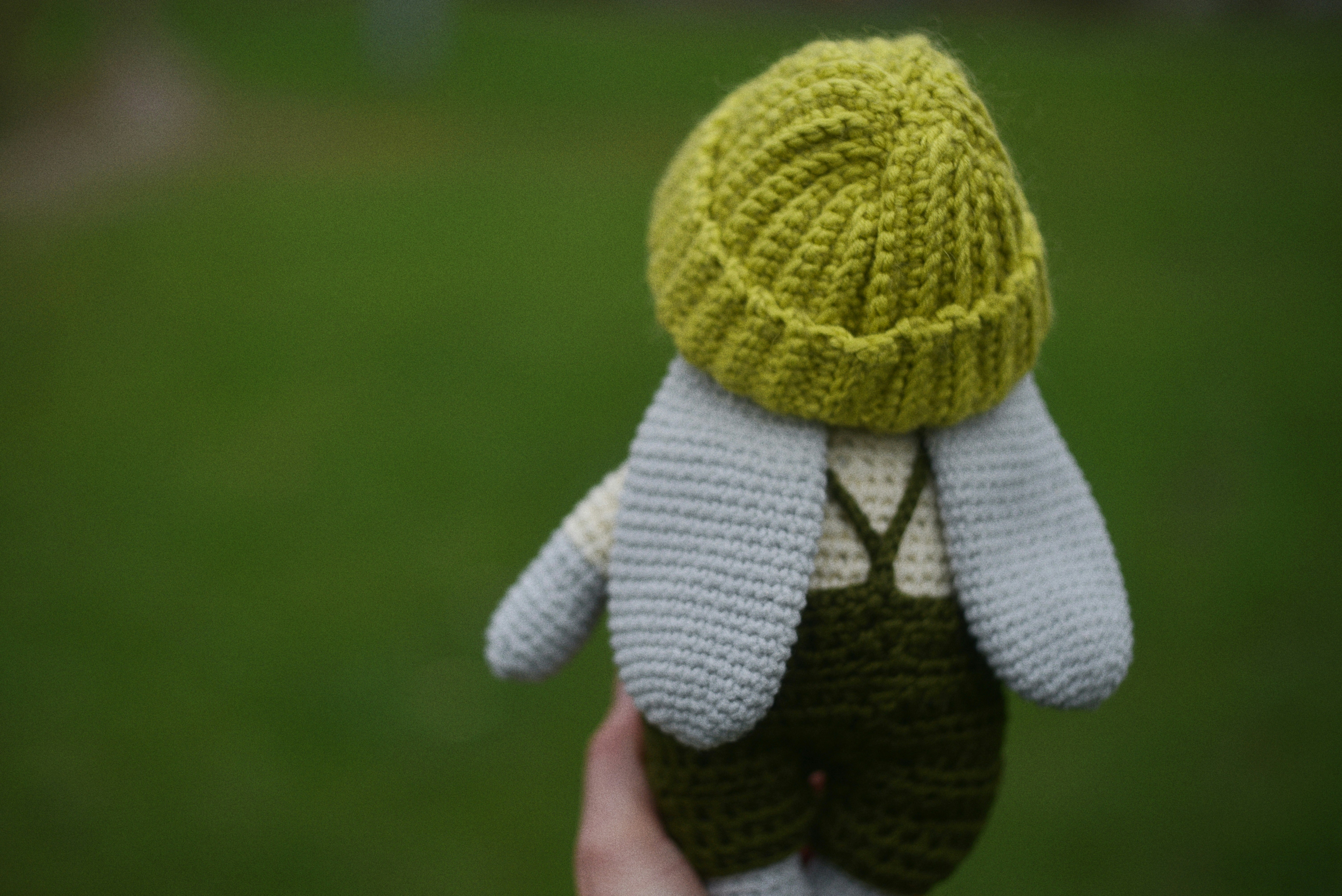 Handheld Plush: A Knit Bunny Cast Against a Blurred Lawn