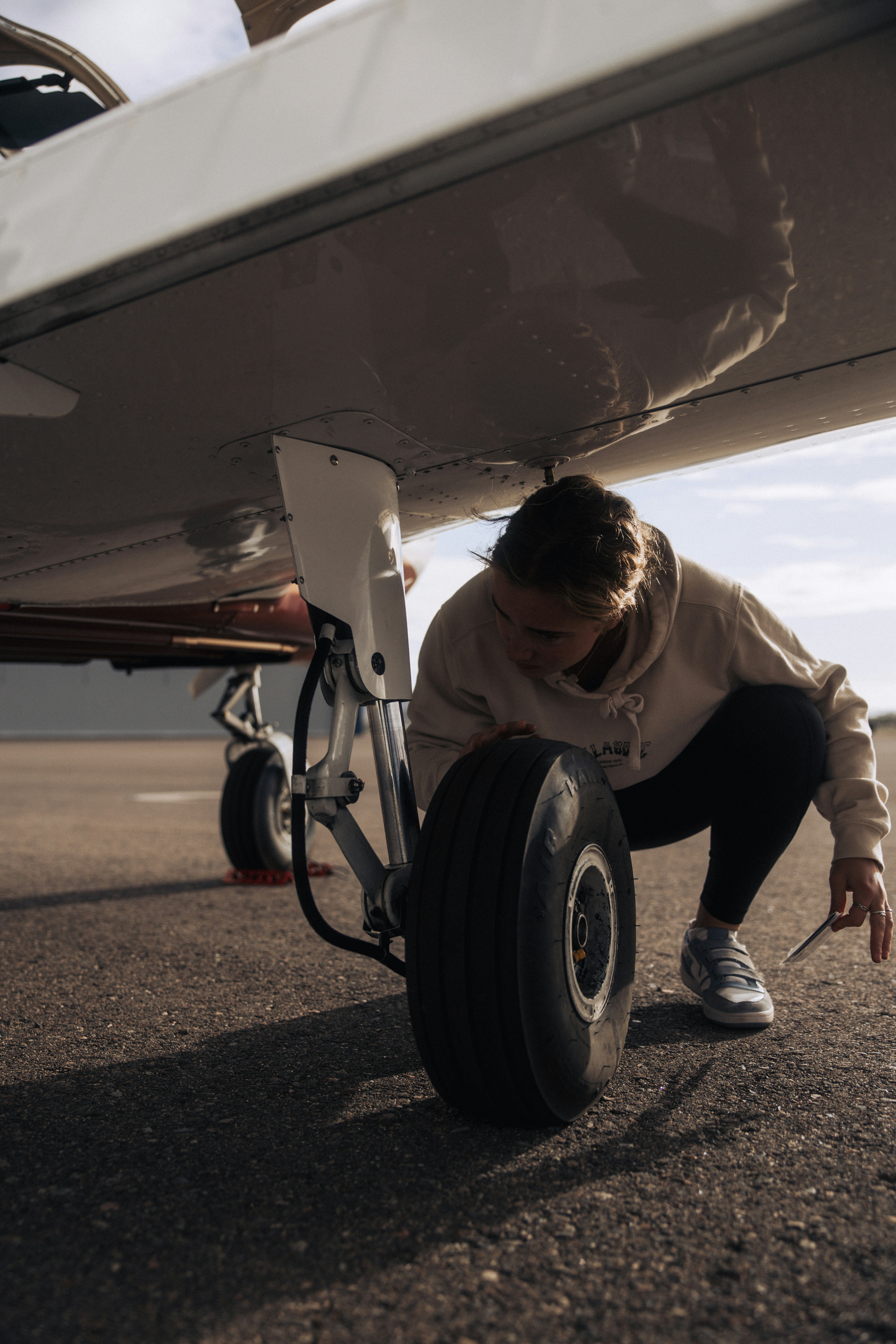 Grounded in Focus: Crew Member Inspecting Aircraft Landing Gear