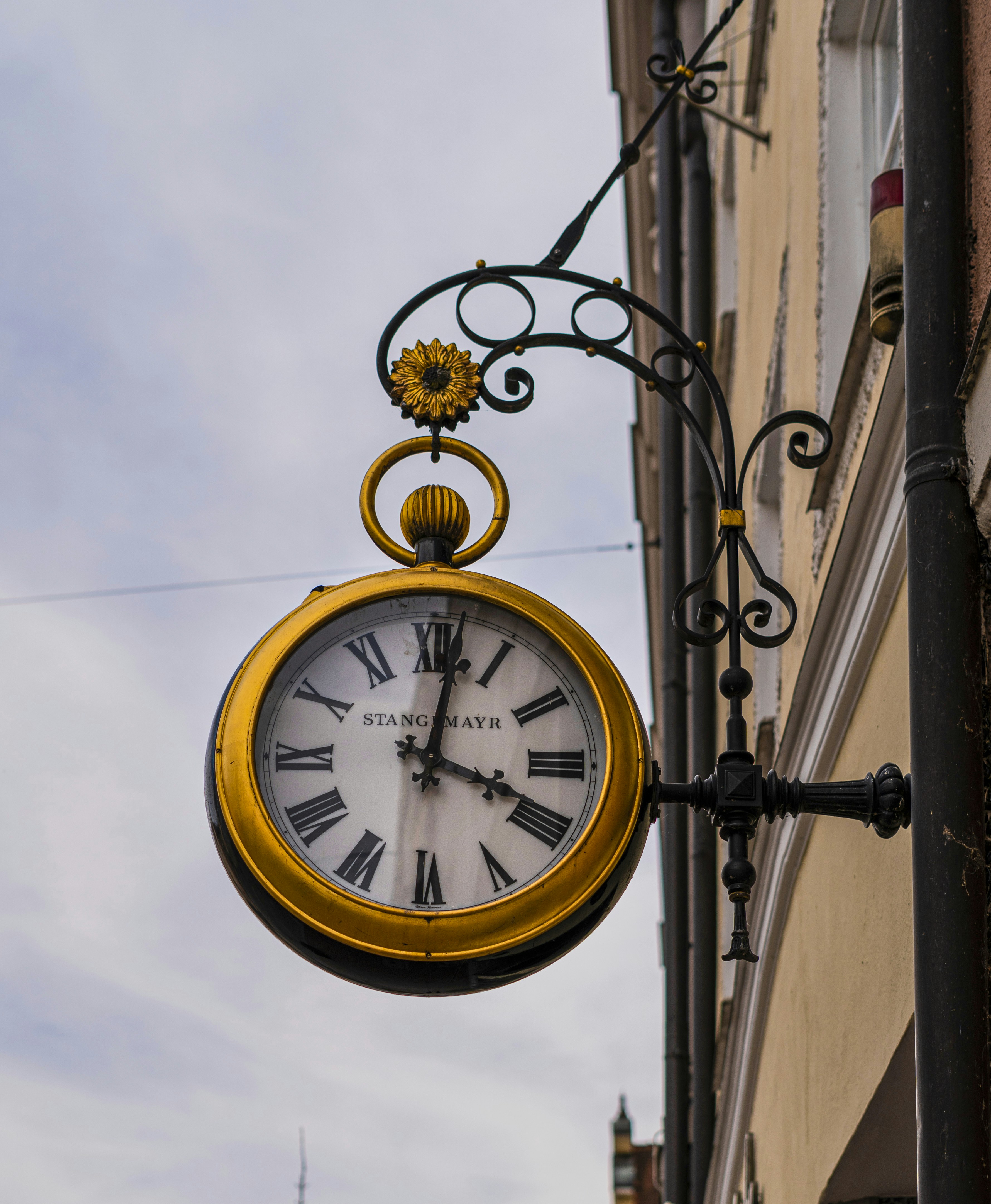 Golden Clockhanger on a Quiet European Facade