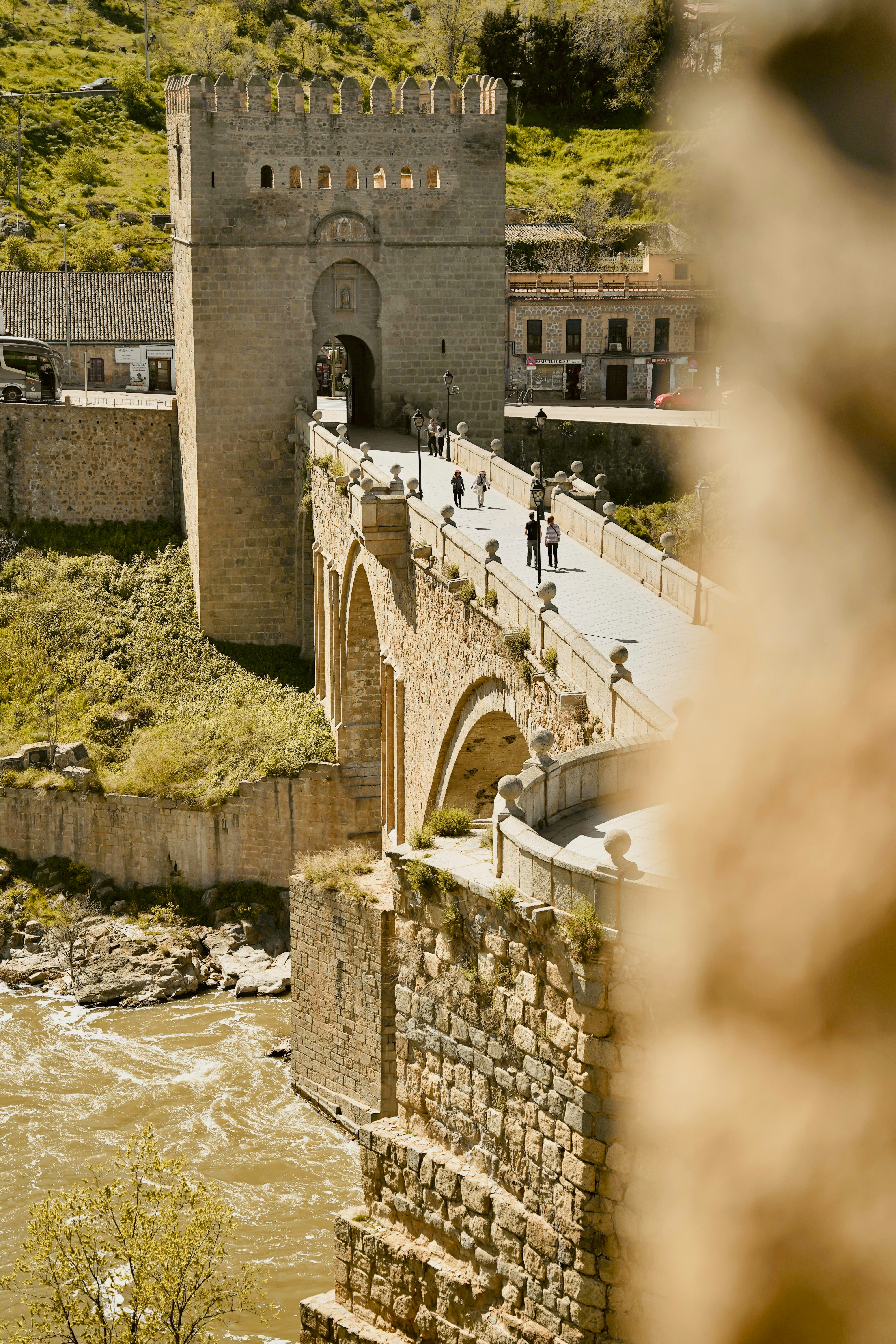 Old Stone Bridge Over a Calm River, Framed by Tower and Cliffs